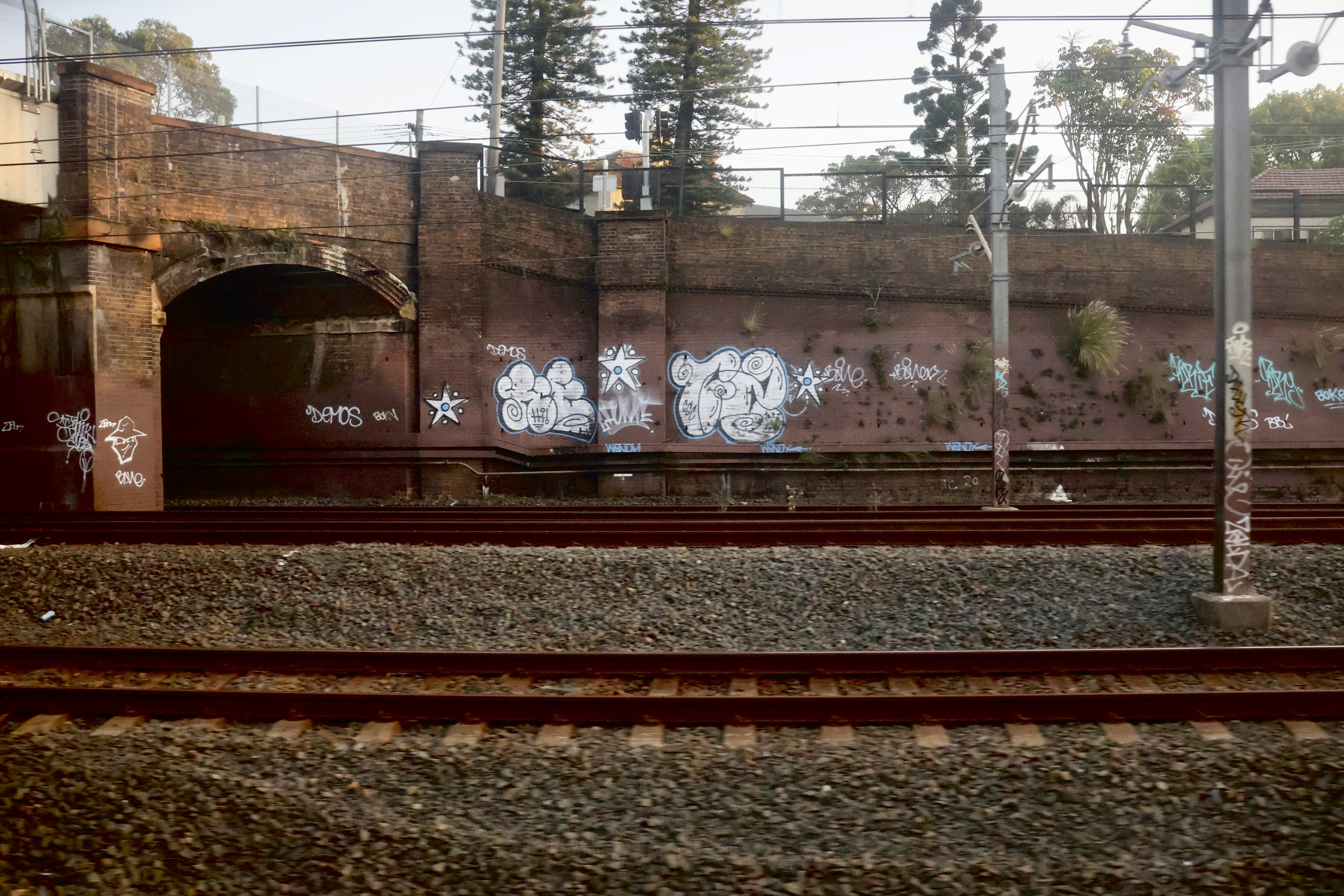 Graffiti Wall by the Rails: An Urban Quiet Between Tracks