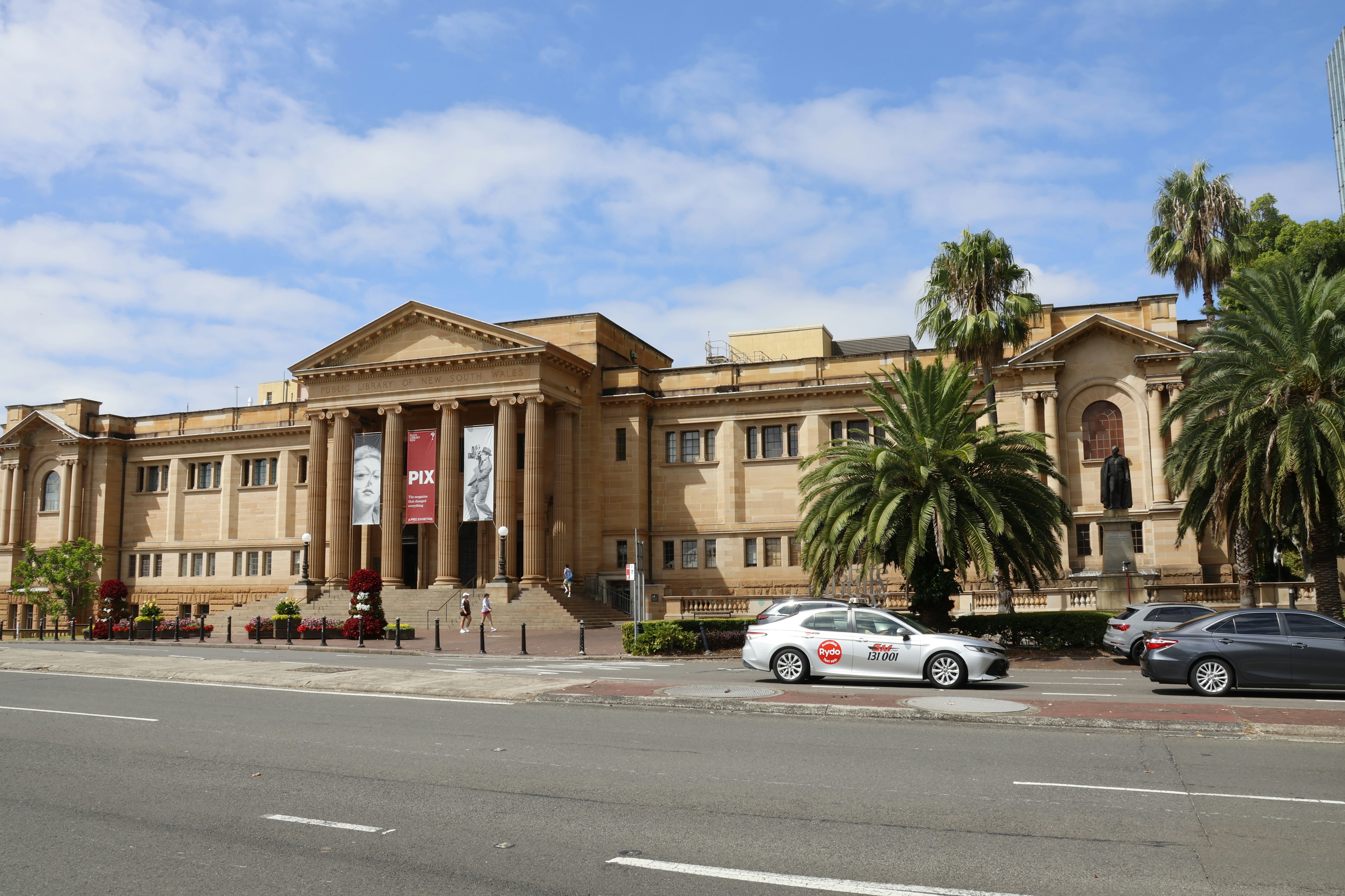 Classical Facade Overlook: A Palm-Fringed Museum Across a Busy Boulevard