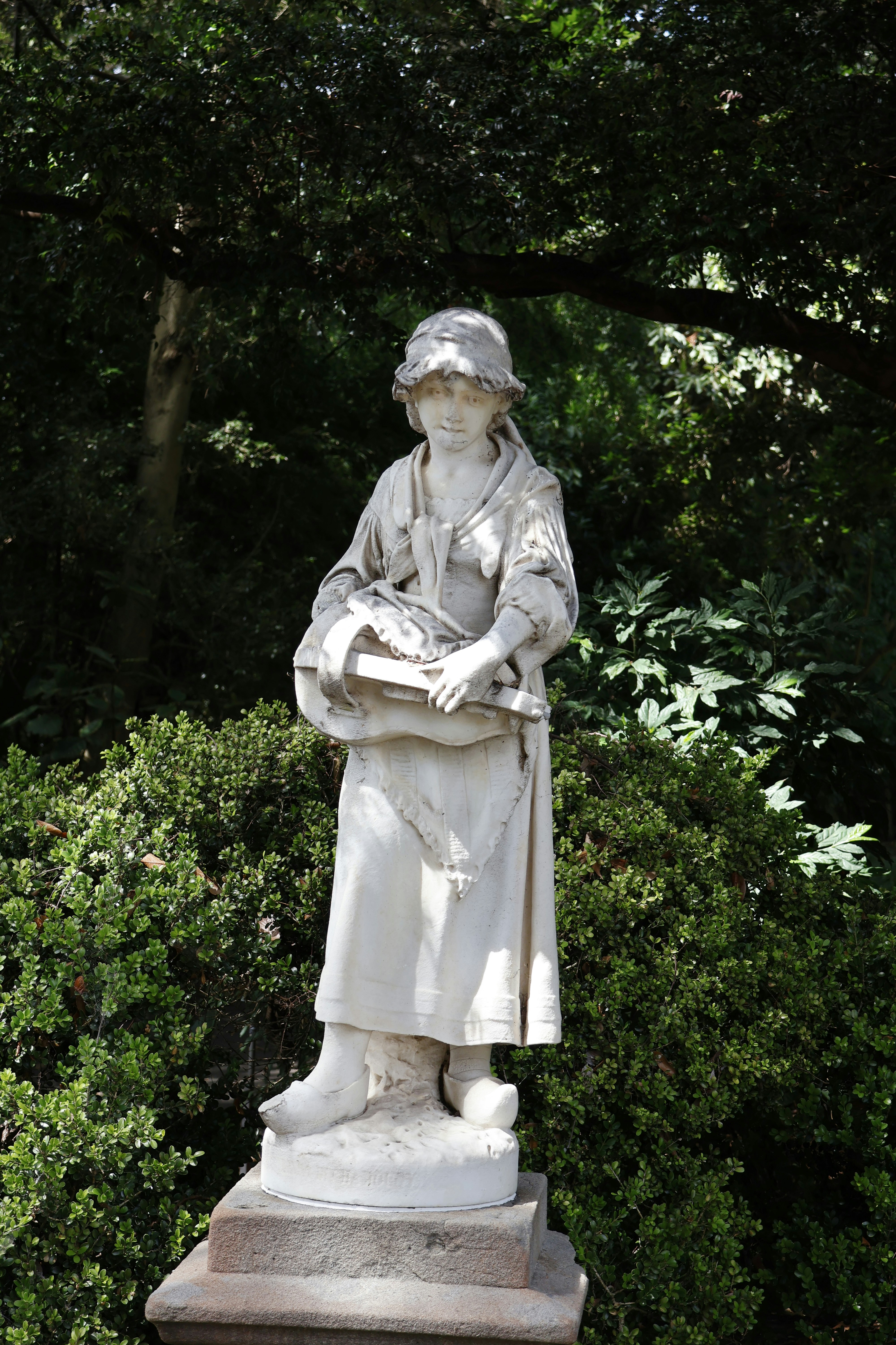 Statue in the Sunlit Garden: A Quiet Gaze among Greenery