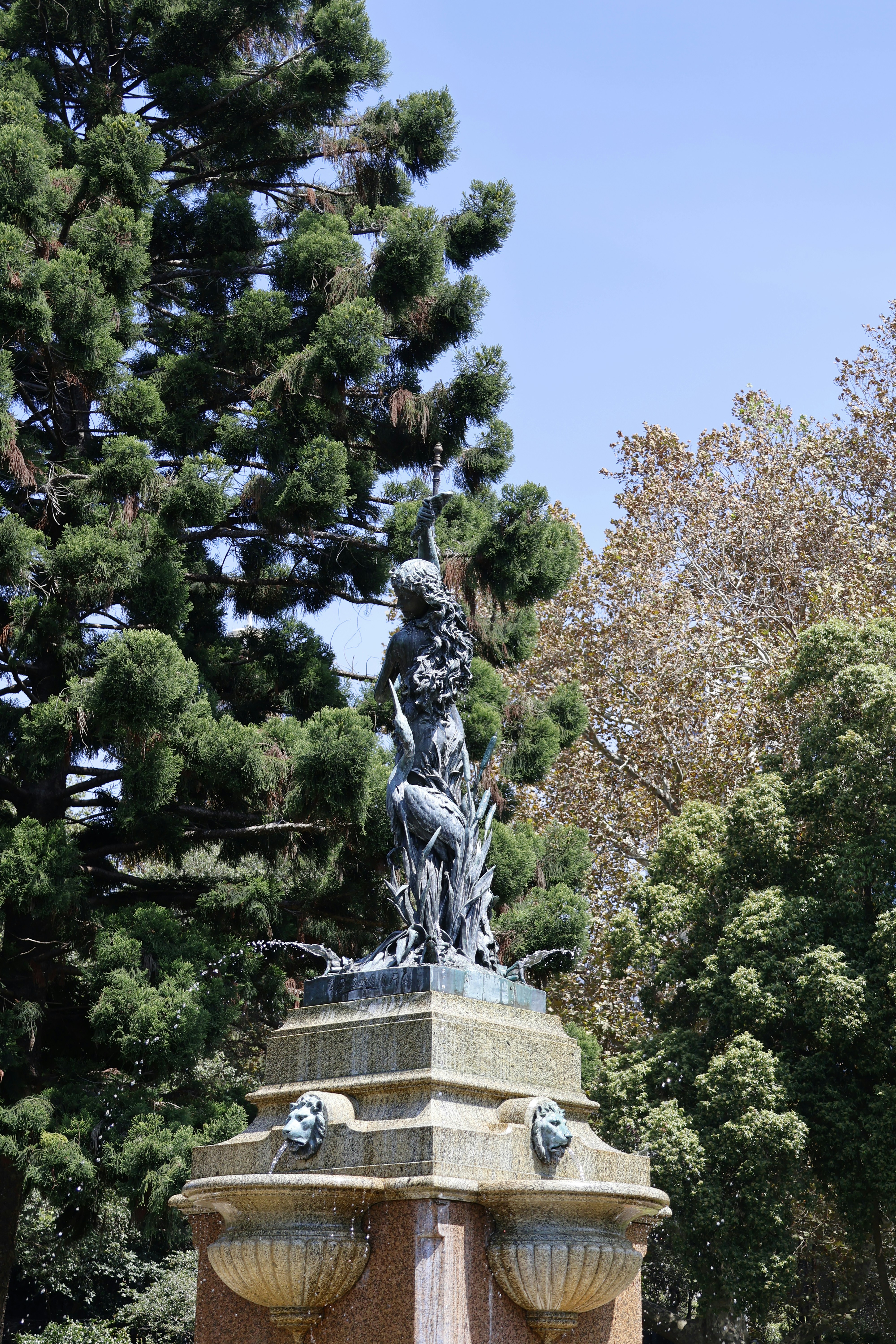 A weathered statue of a woman amidst foliage photo – Free Garden Image ...