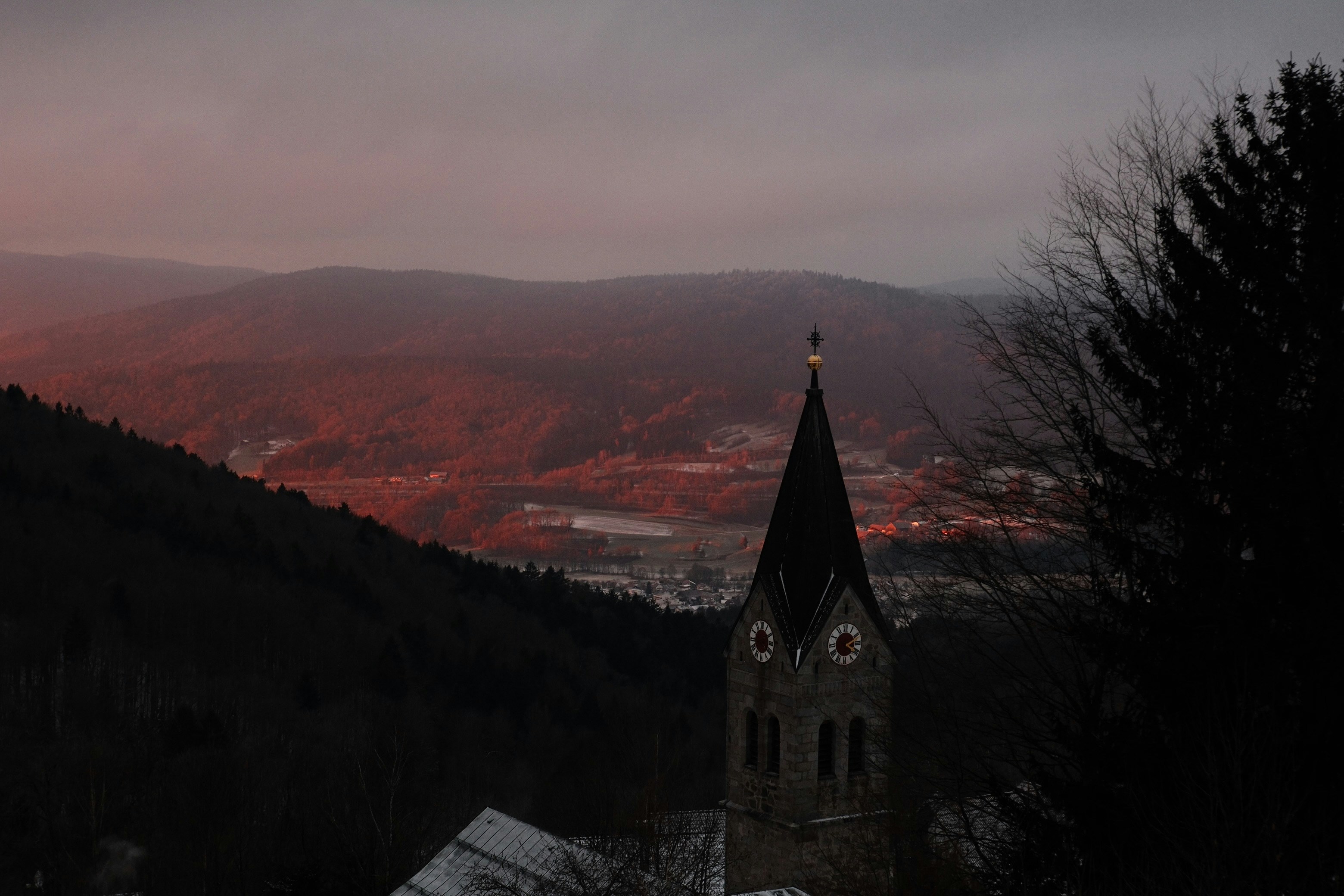 Church steeple overlooks valley at dusk