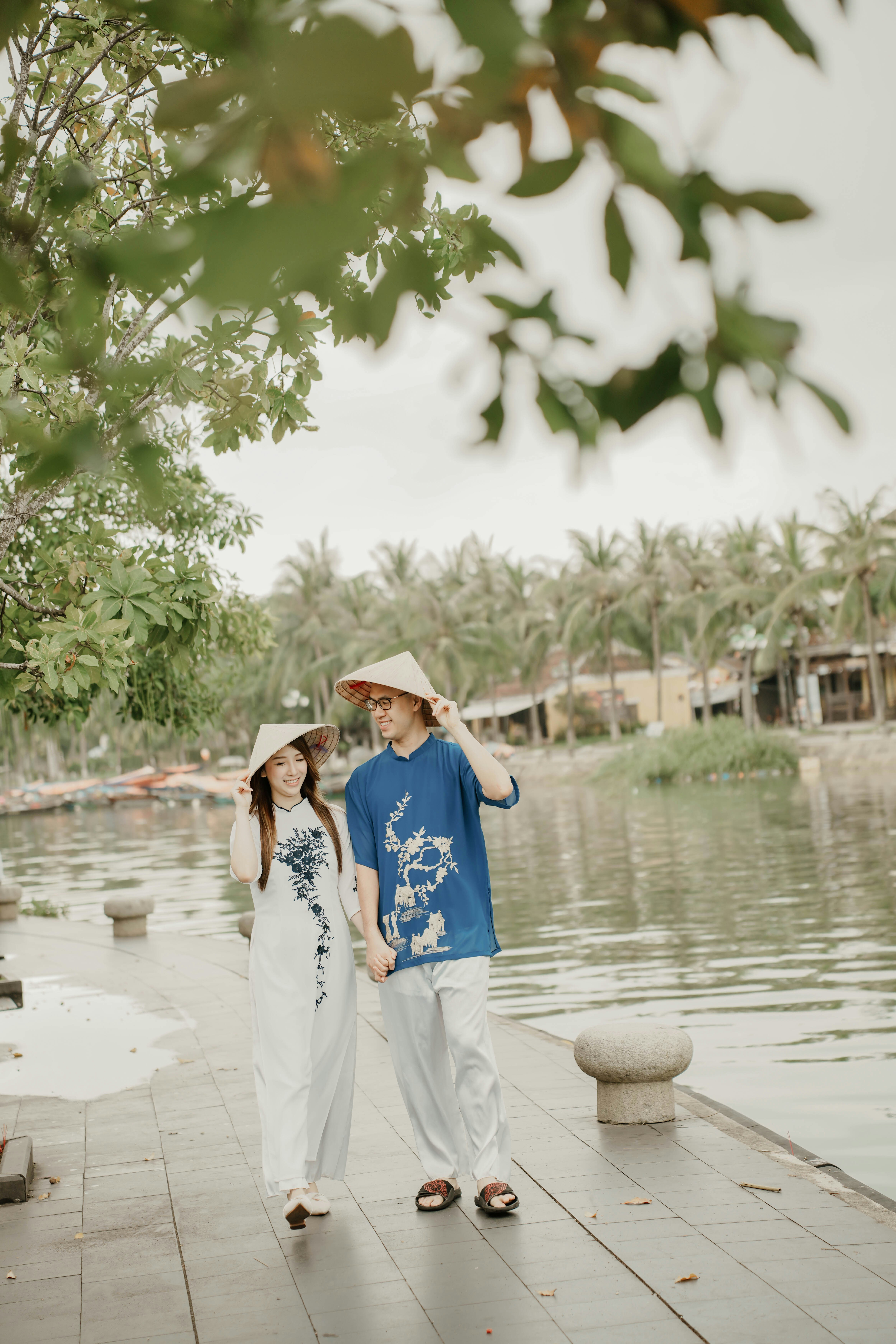 Lovers' stroll by the lantern-lit canal in a sunlit coastal village