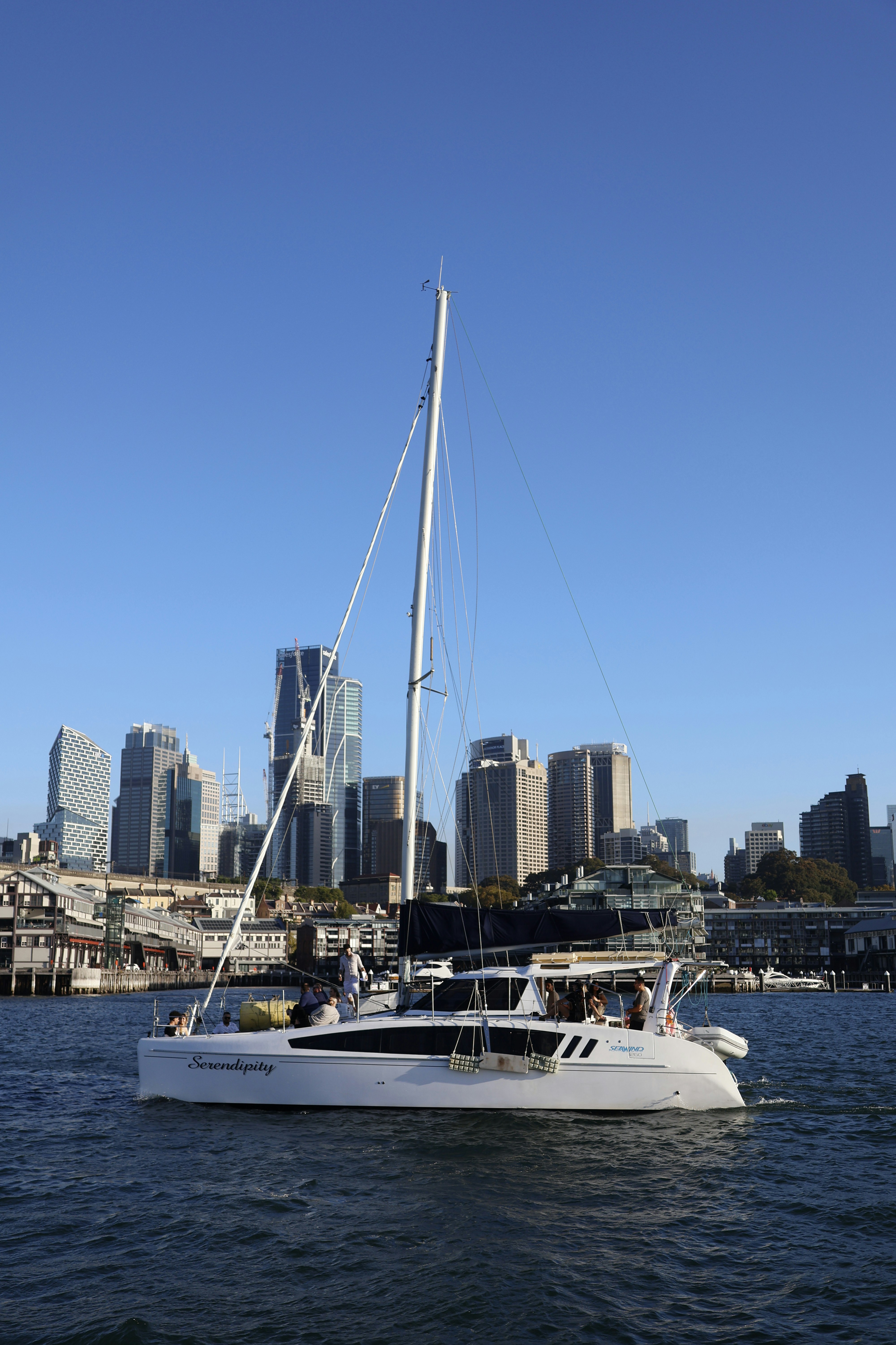 Sailing Silhouette Against a Modern Waterfront