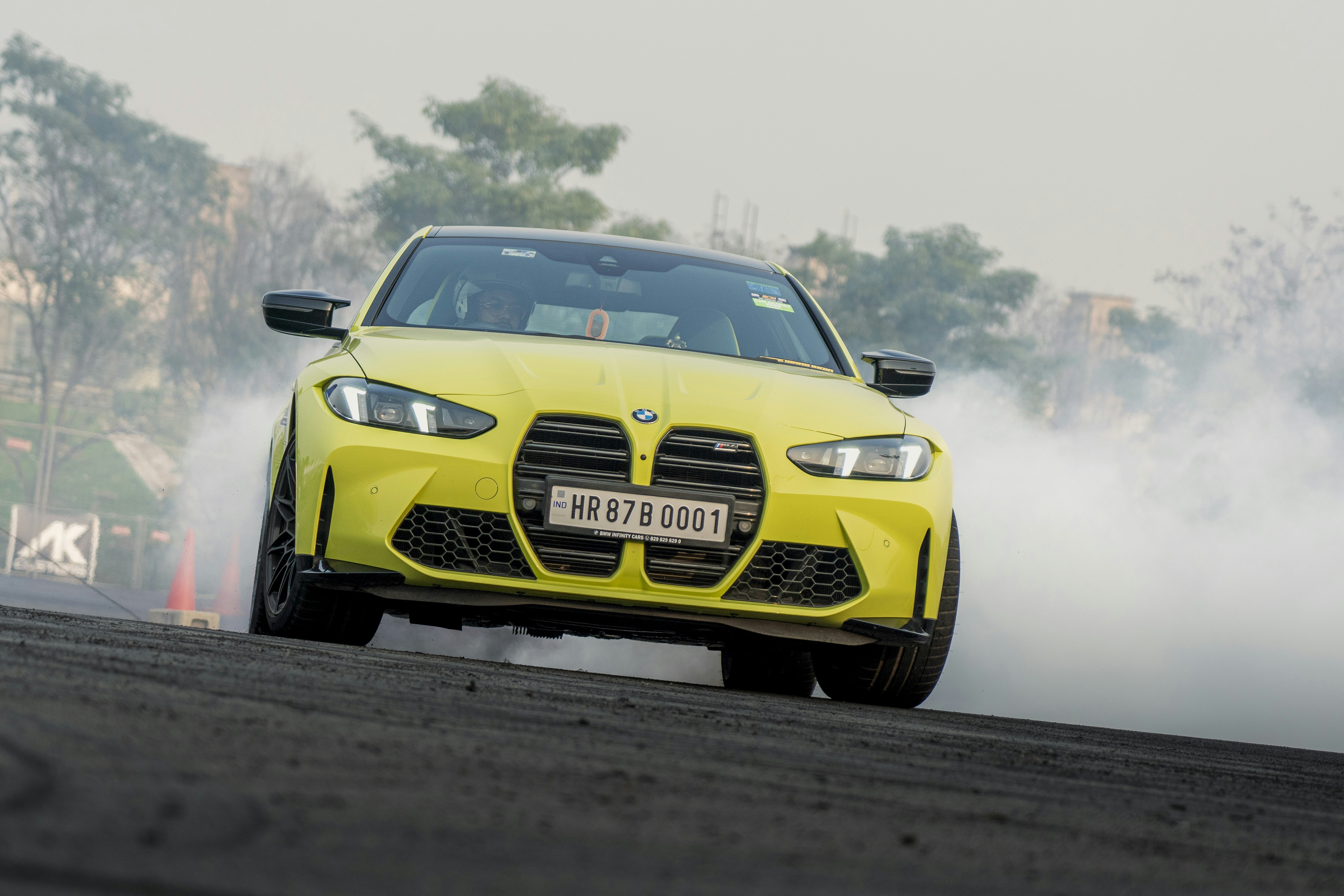 Yellow sedan powers through smoke: a low-angle drift reveal