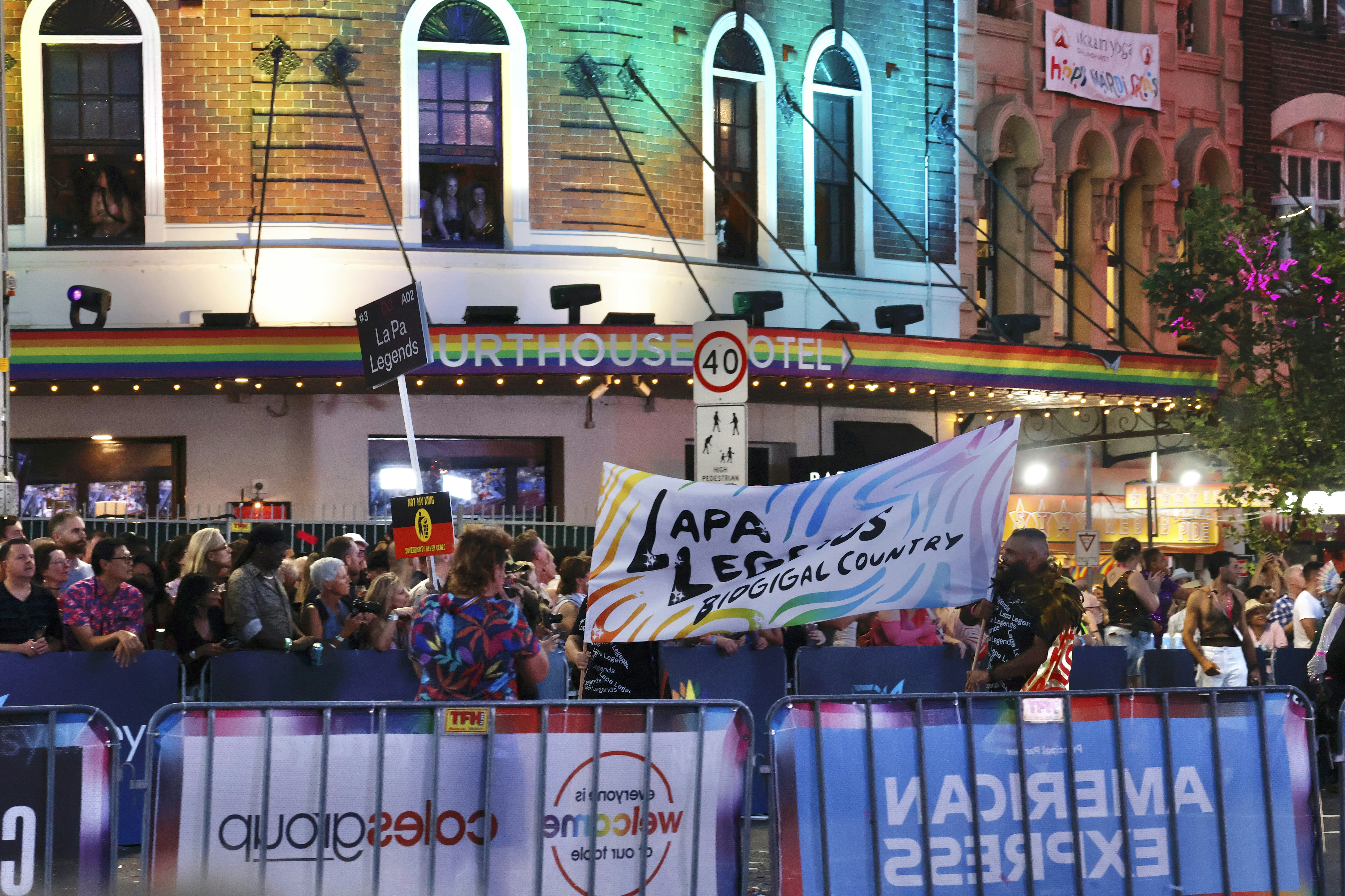 Neon-lit Facade and Crowd at Pride Week Street Celebration