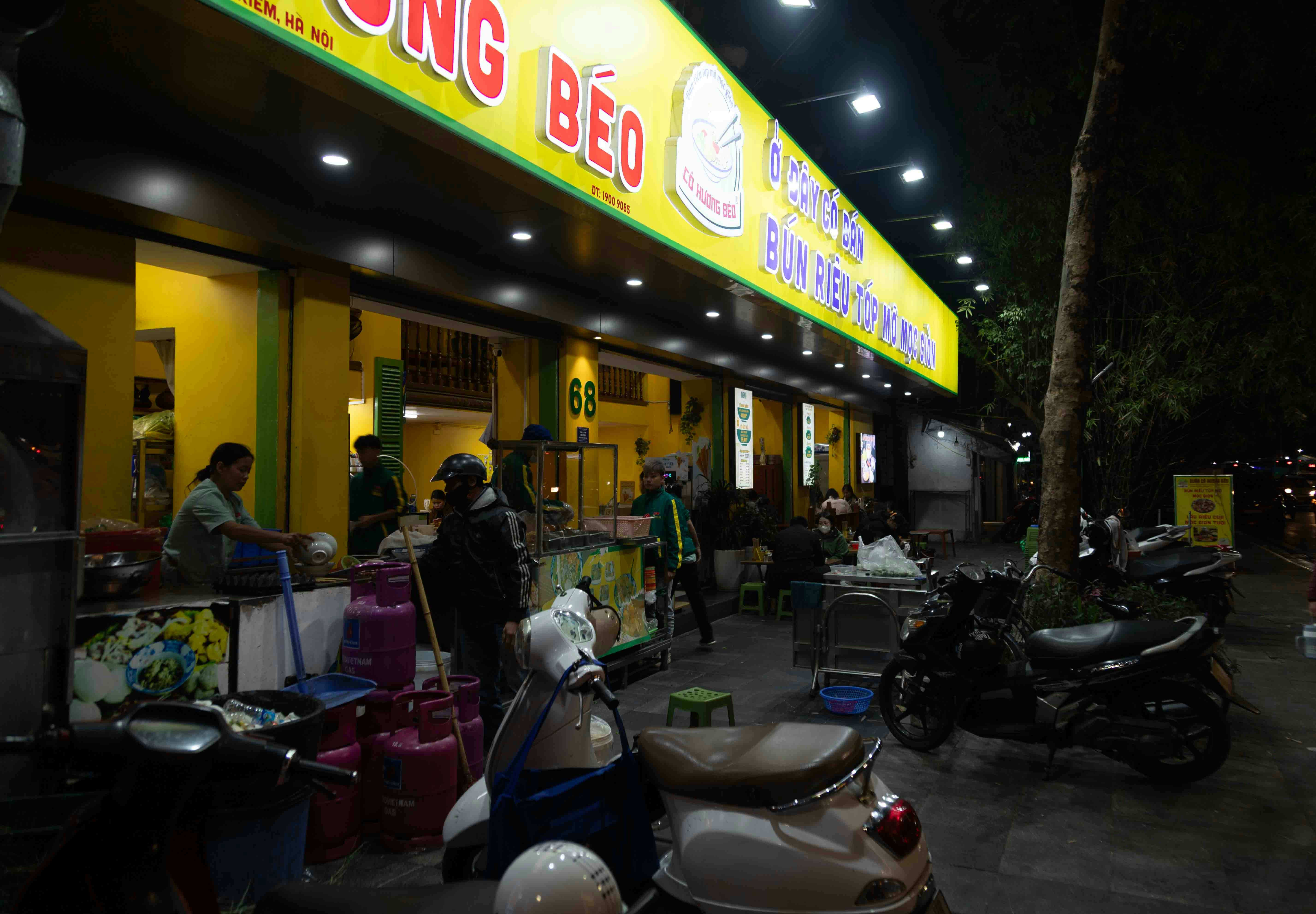 A brightly lit restaurant storefront at night. photo – Free Scooter ...