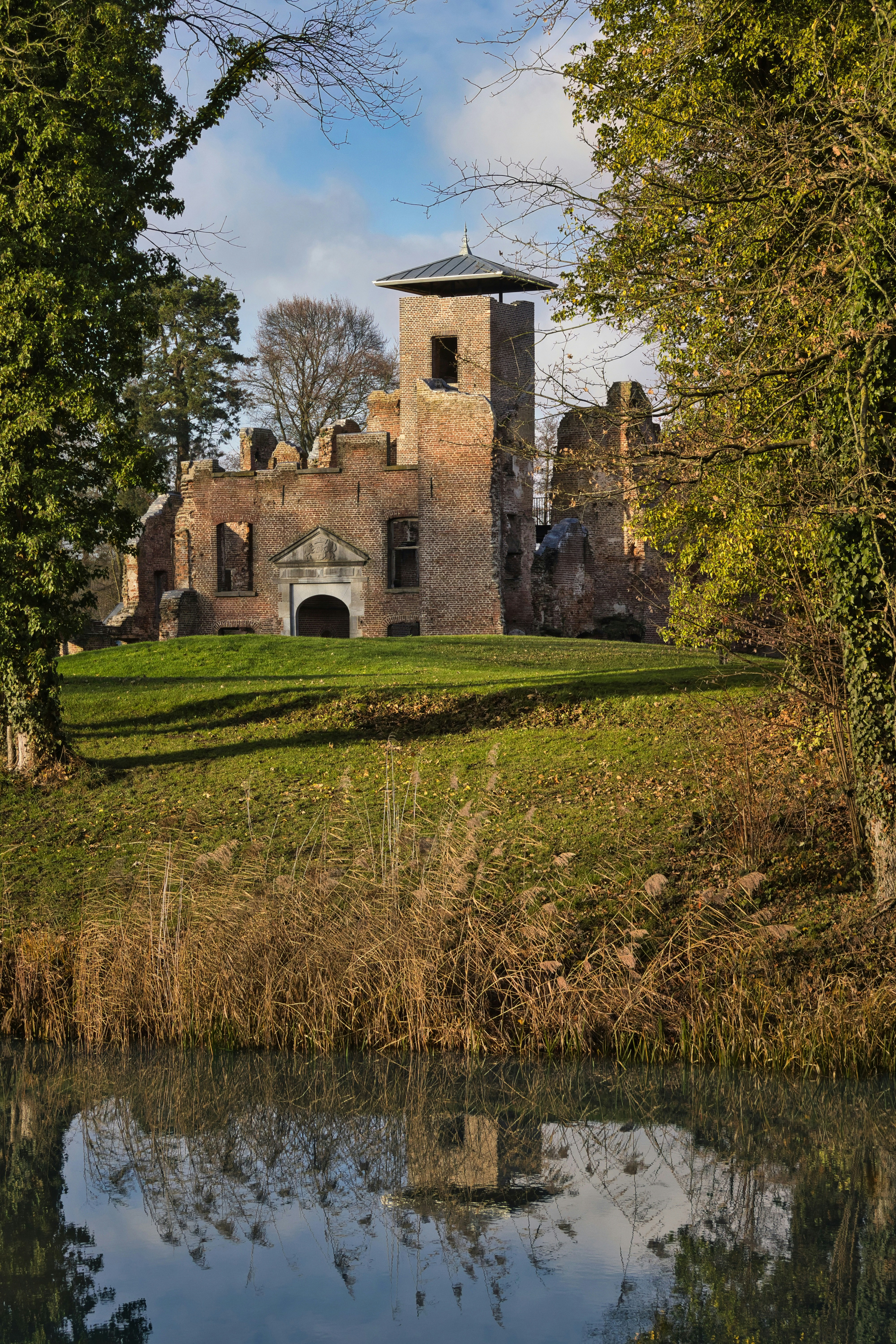 Ruined fortress by the tranquil river, framed by autumn foliage
