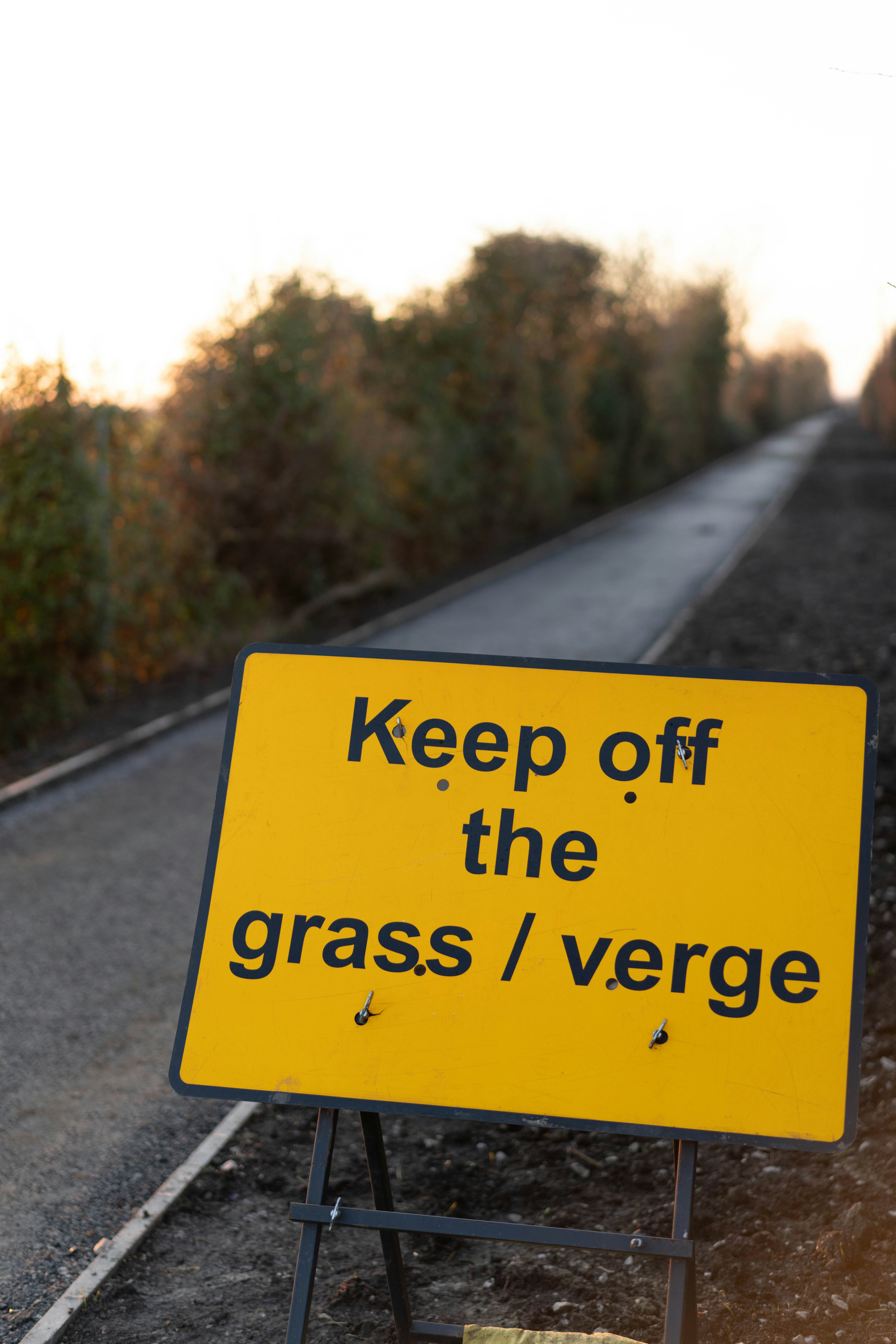 Warning Sign on a Quiet Path: Keep Off the Verge