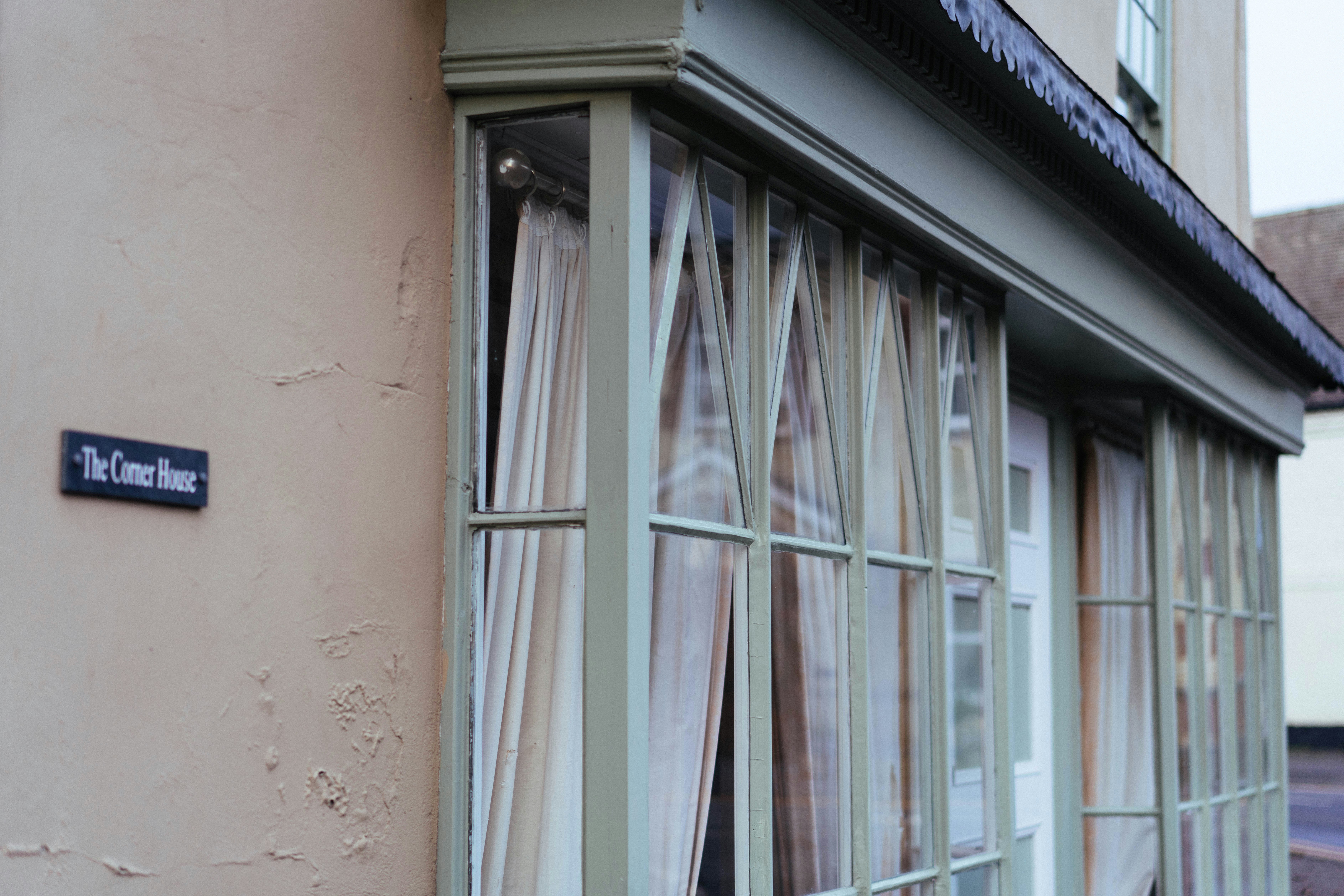 The Corner Storefront with Faded Sign and Curtain-lined Windows