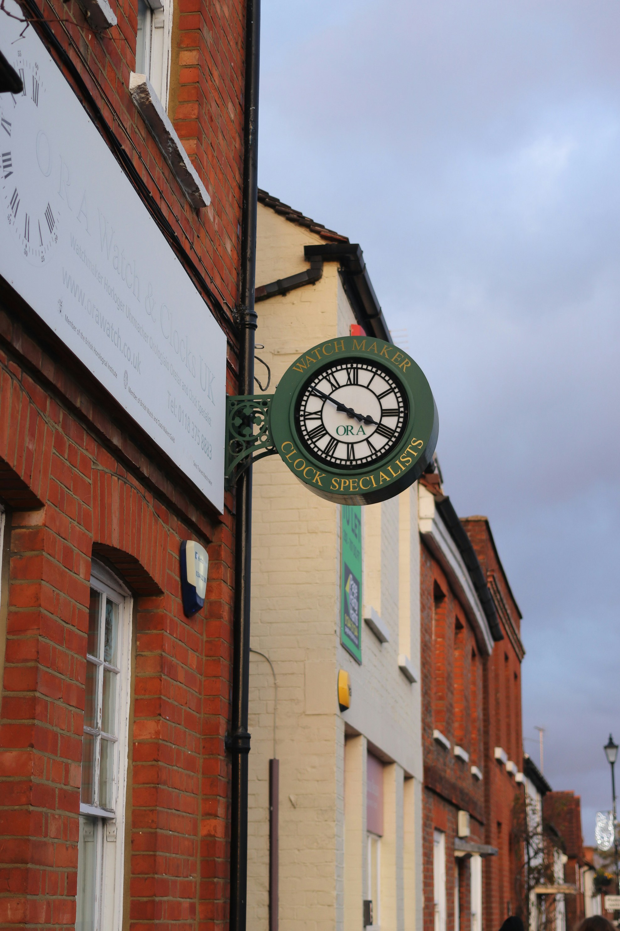 Clock Sign on a Brick Street: A Quiet Village Timepiece