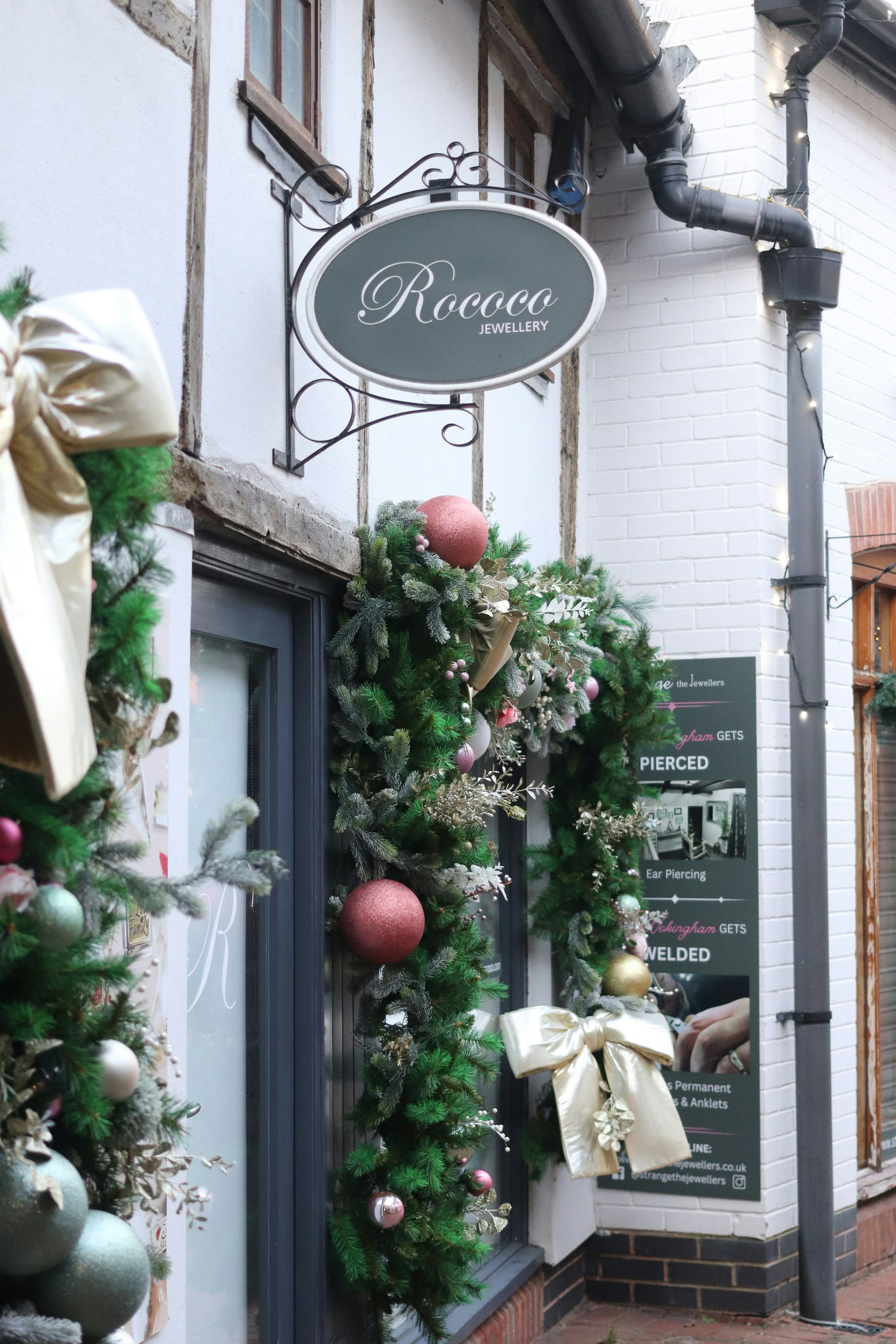 Festive storefront archway framed by evergreen garlands at Rococo Jewellery
