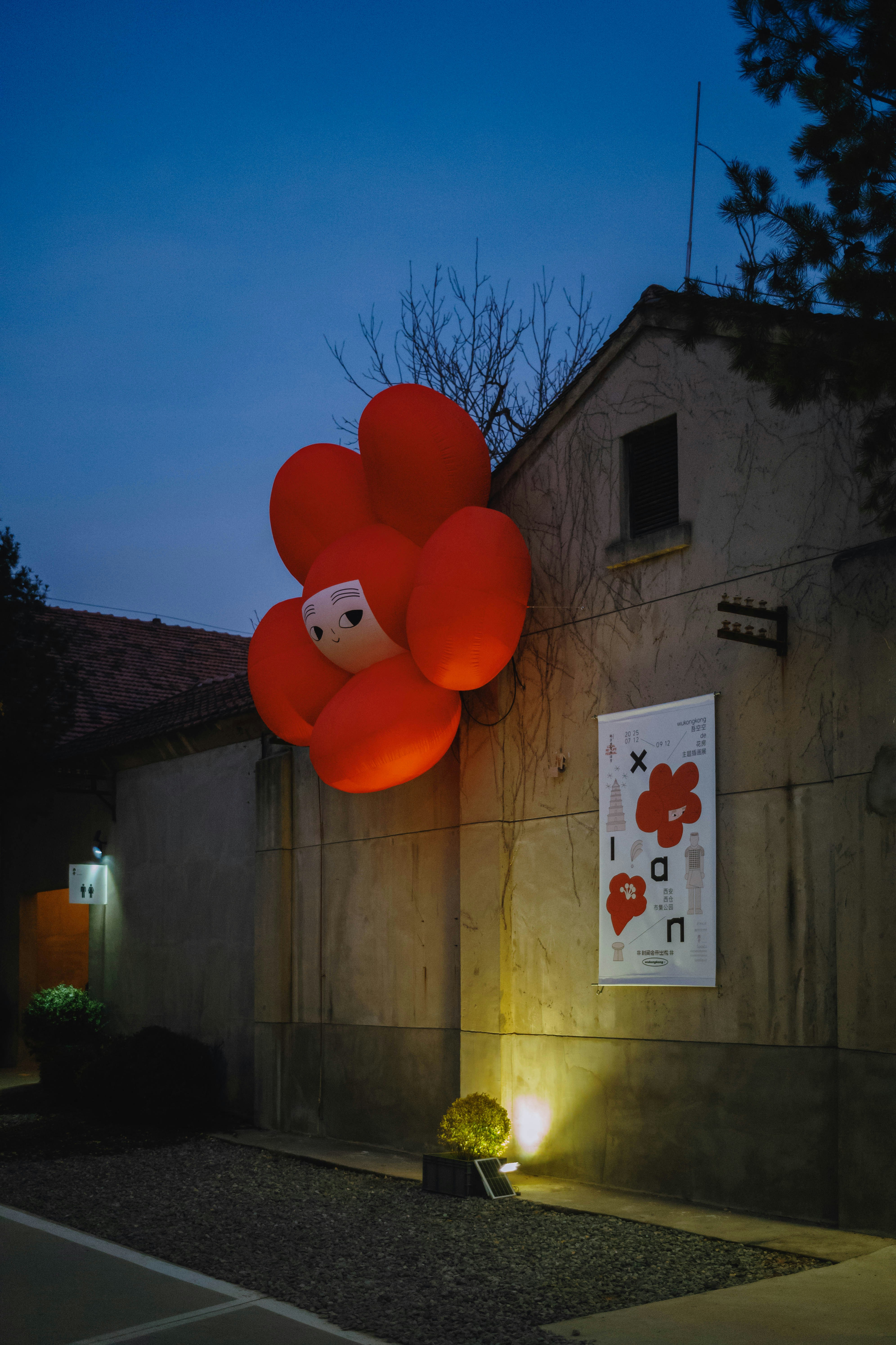 Red Balloon Bouquet Adorning the Cornered Wall at Dusk