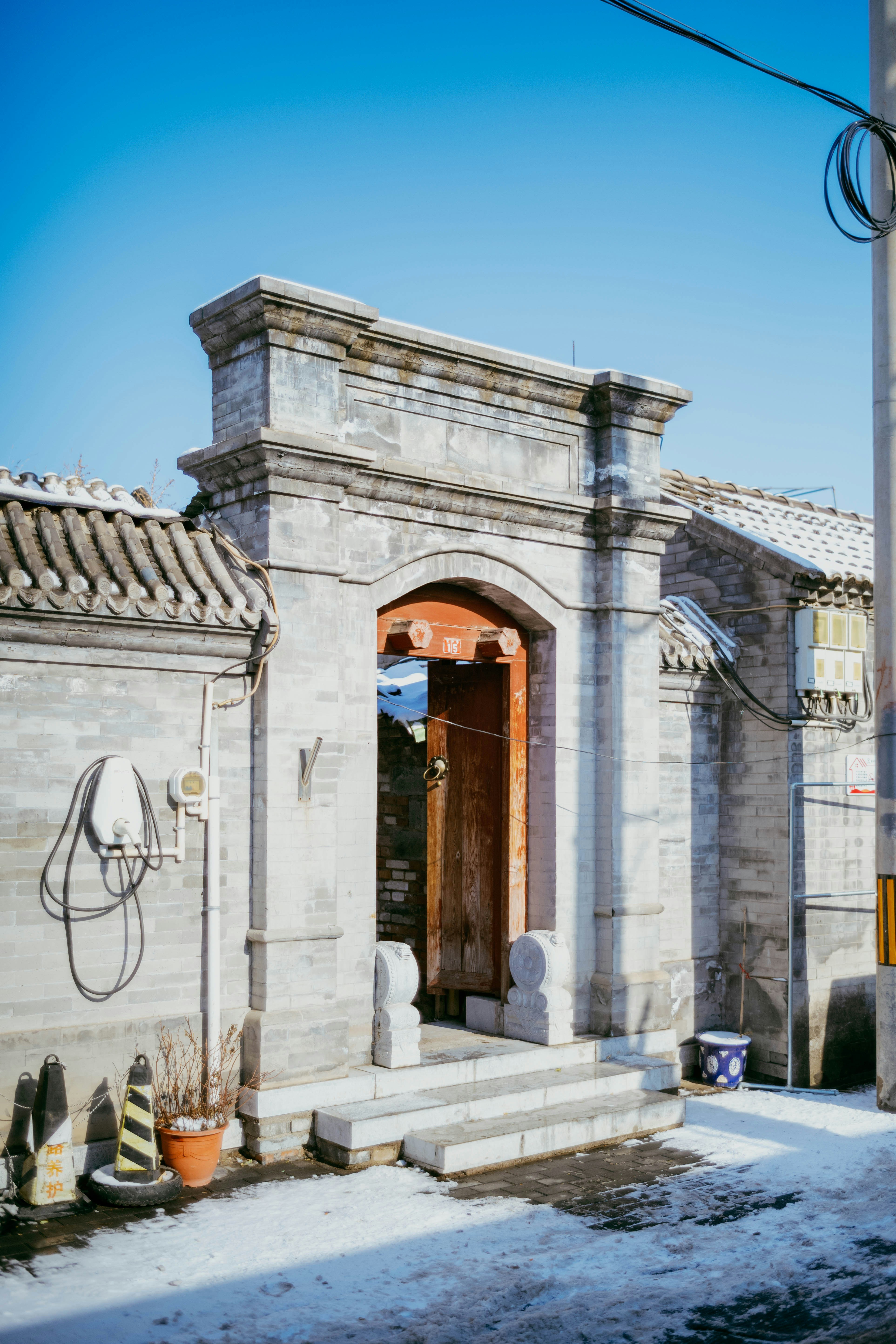Entrance through the stone arch: a quiet courtyard doorway in winter light