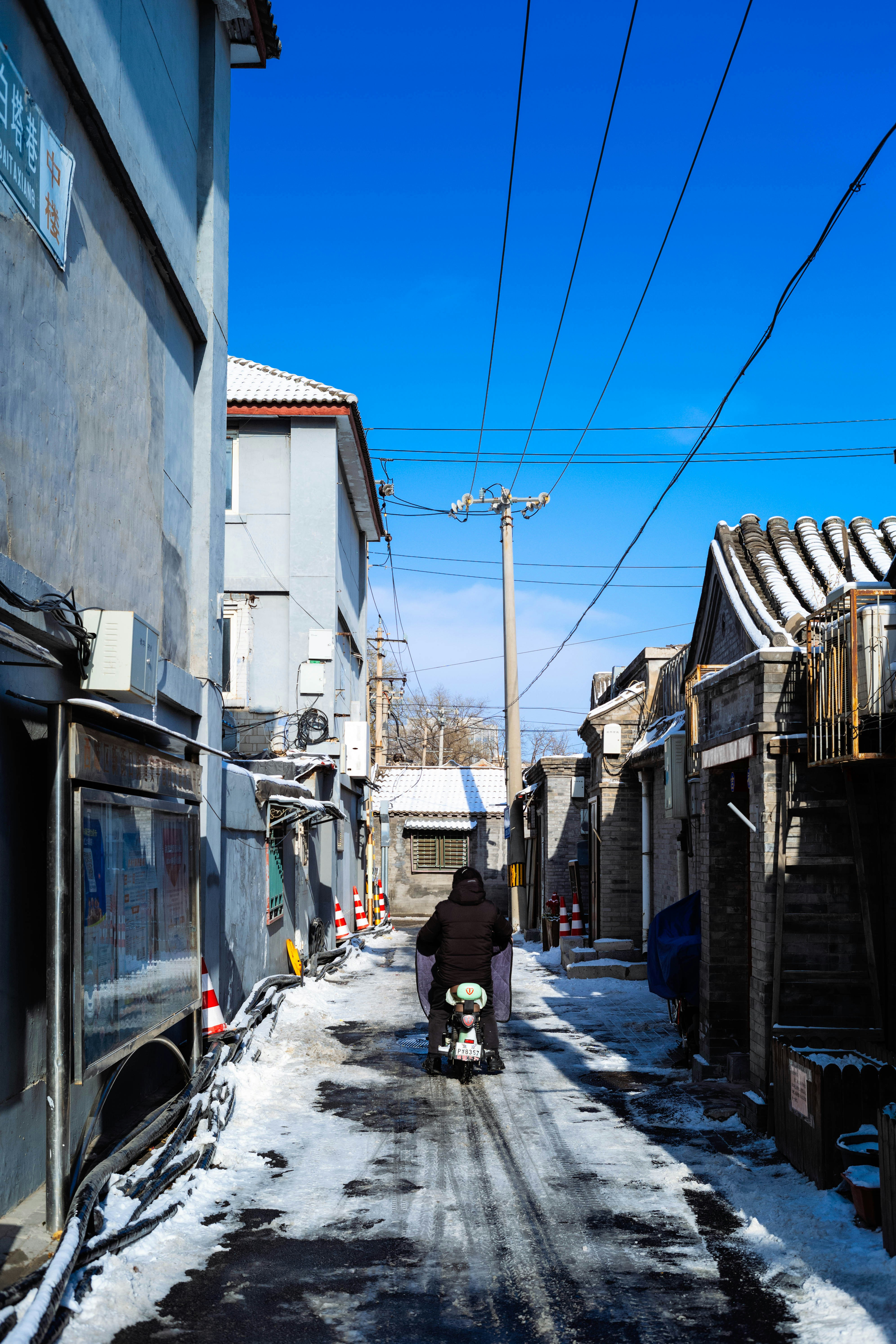 Snow-Cleared Alley Dorsal: A Rider Pushes Through Quiet Winter Circuits