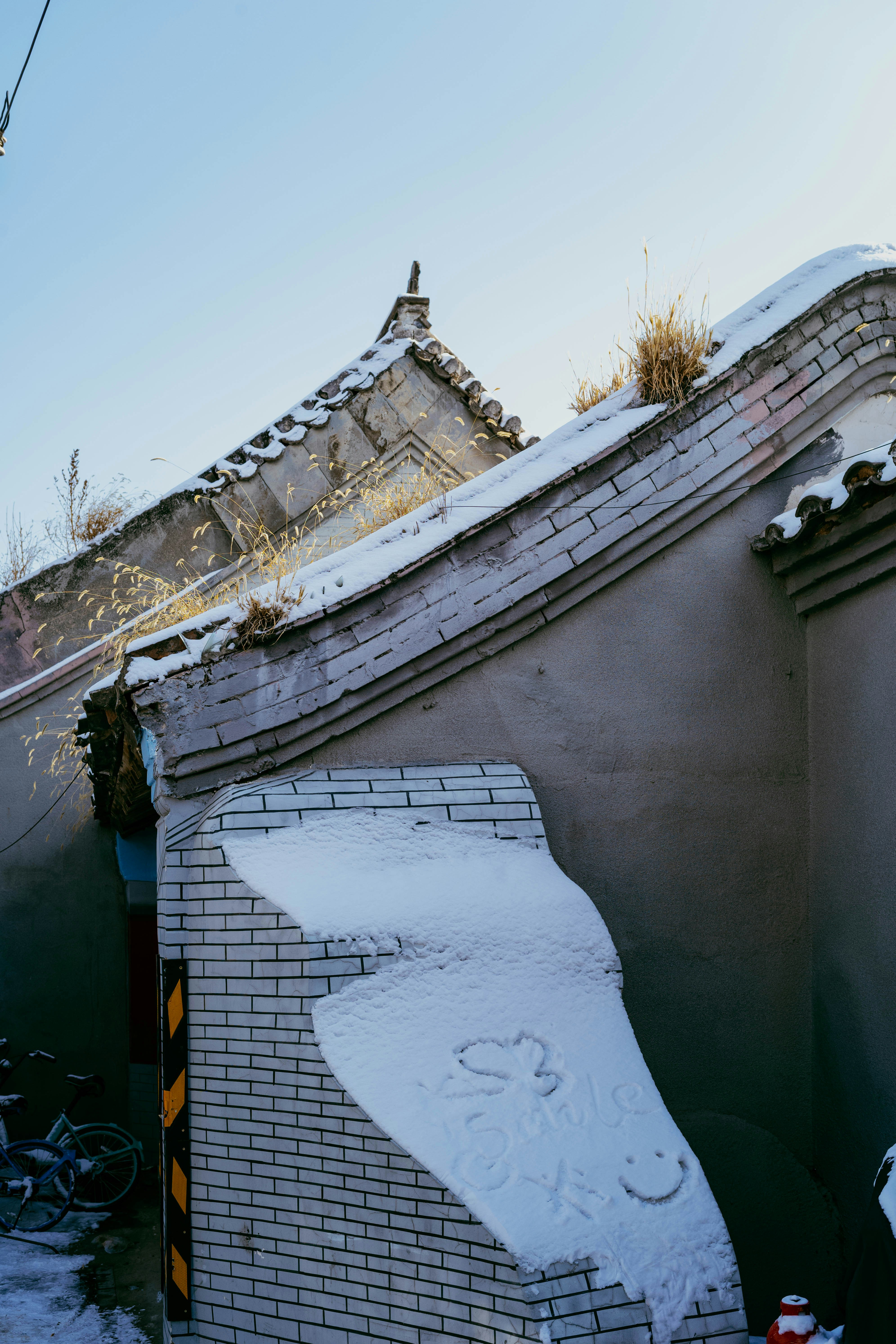 Snow-Capped Rooftops and Curved Wall in a Quiet Alley