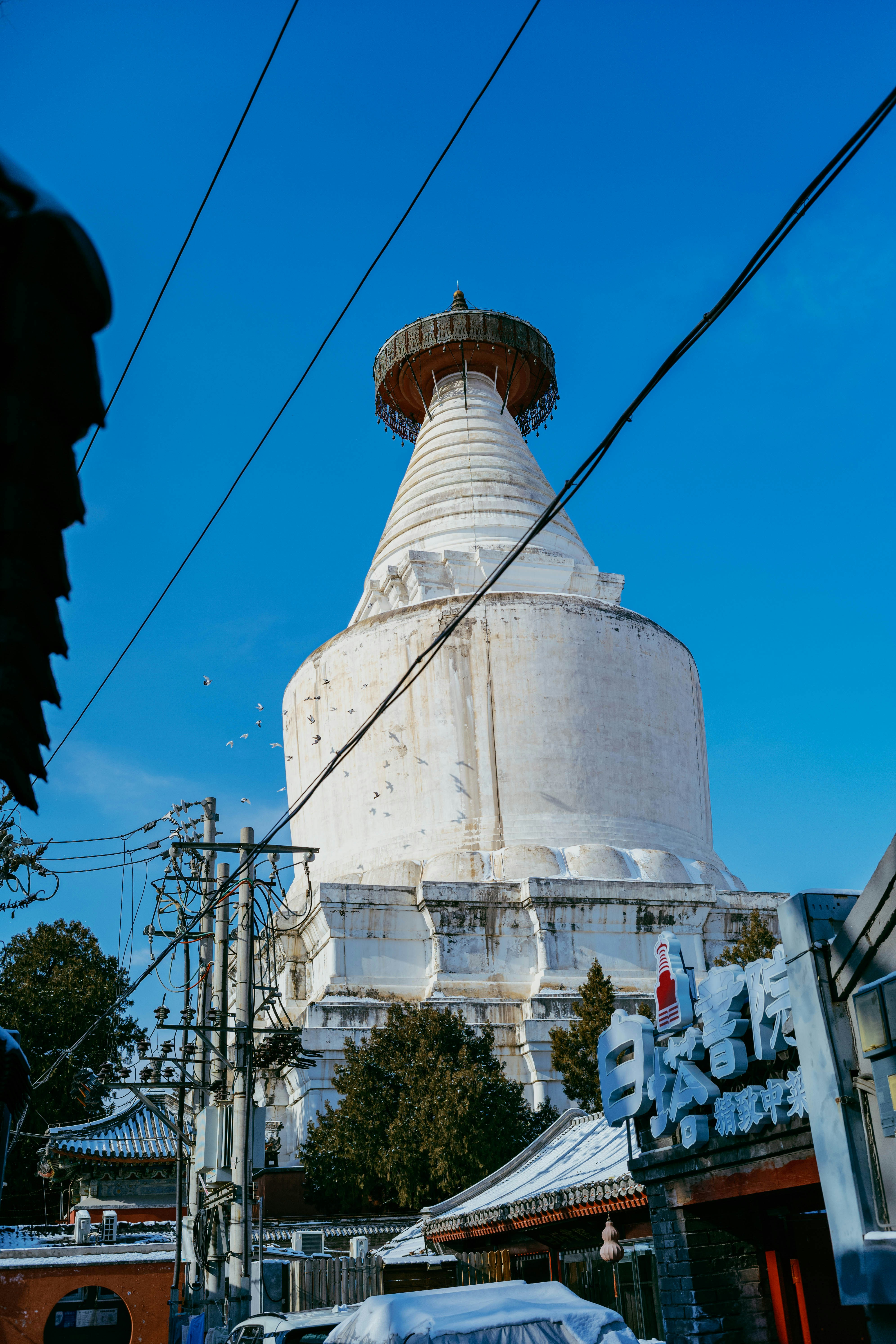 White Stupa under a Clear Blue Sky, Framed by Urban Elements
