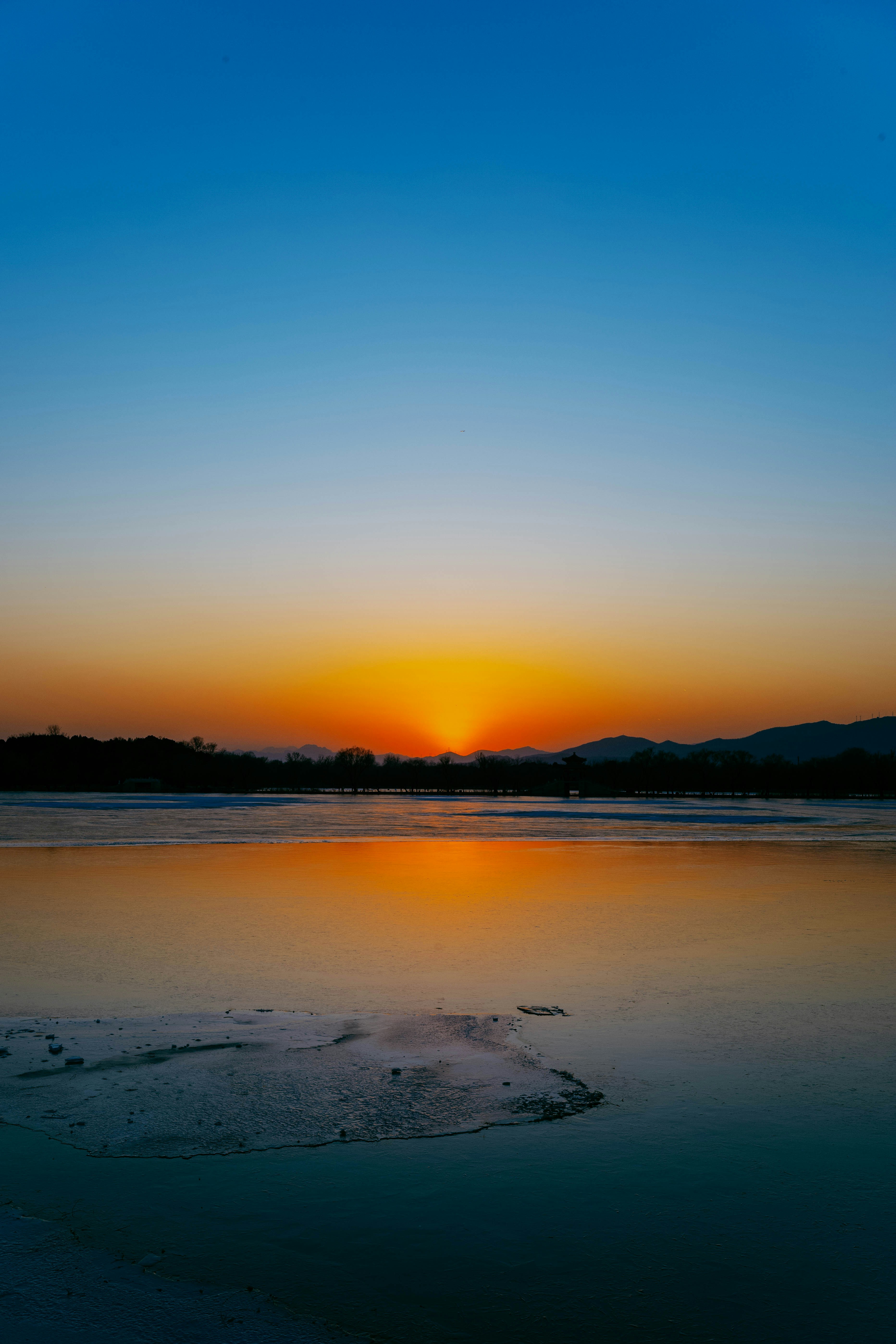Sunset Silhouette Over a Quiet Freeze of the Lake