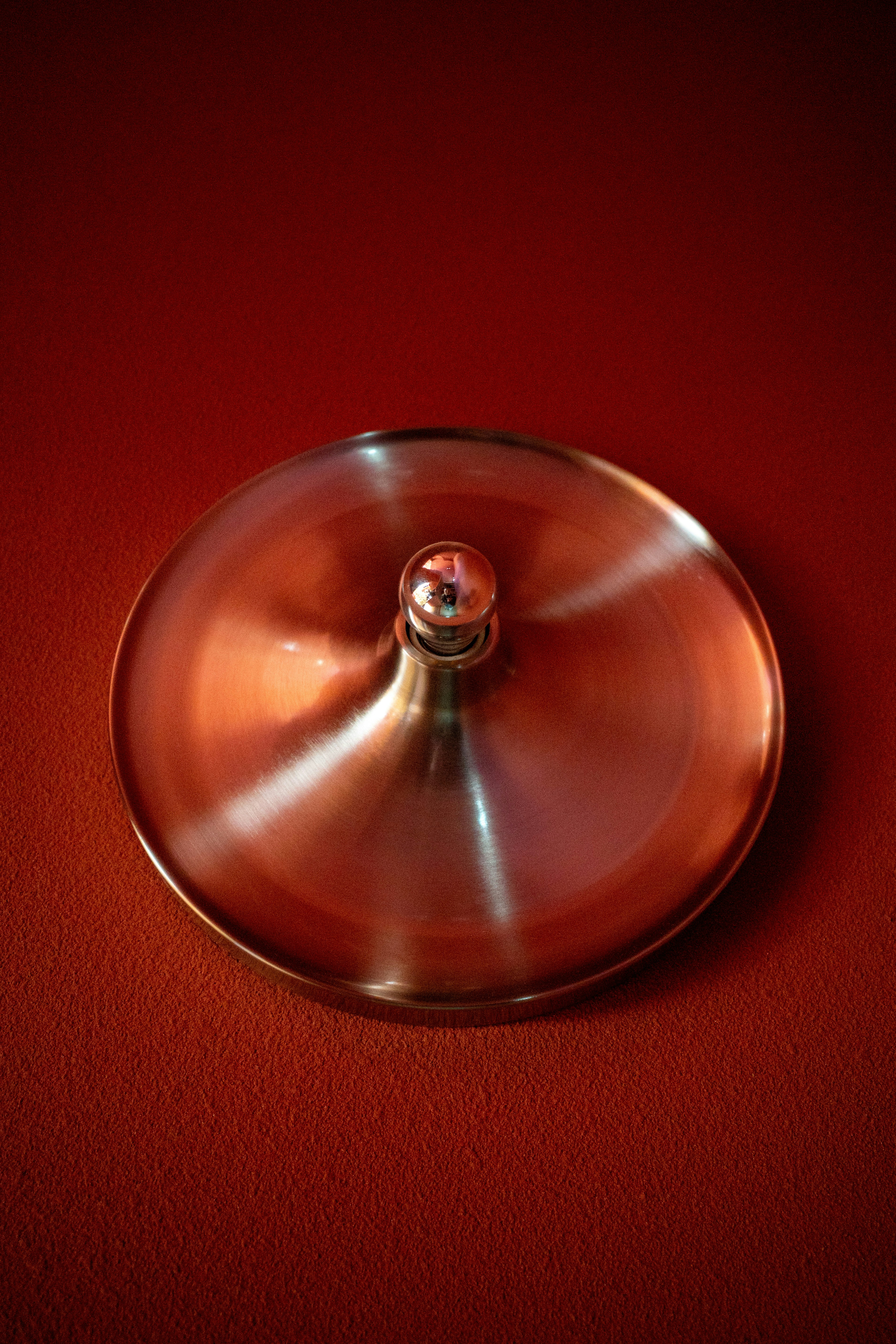 Copper Halo: A Top-Down Glint on a Shallow Red Surface