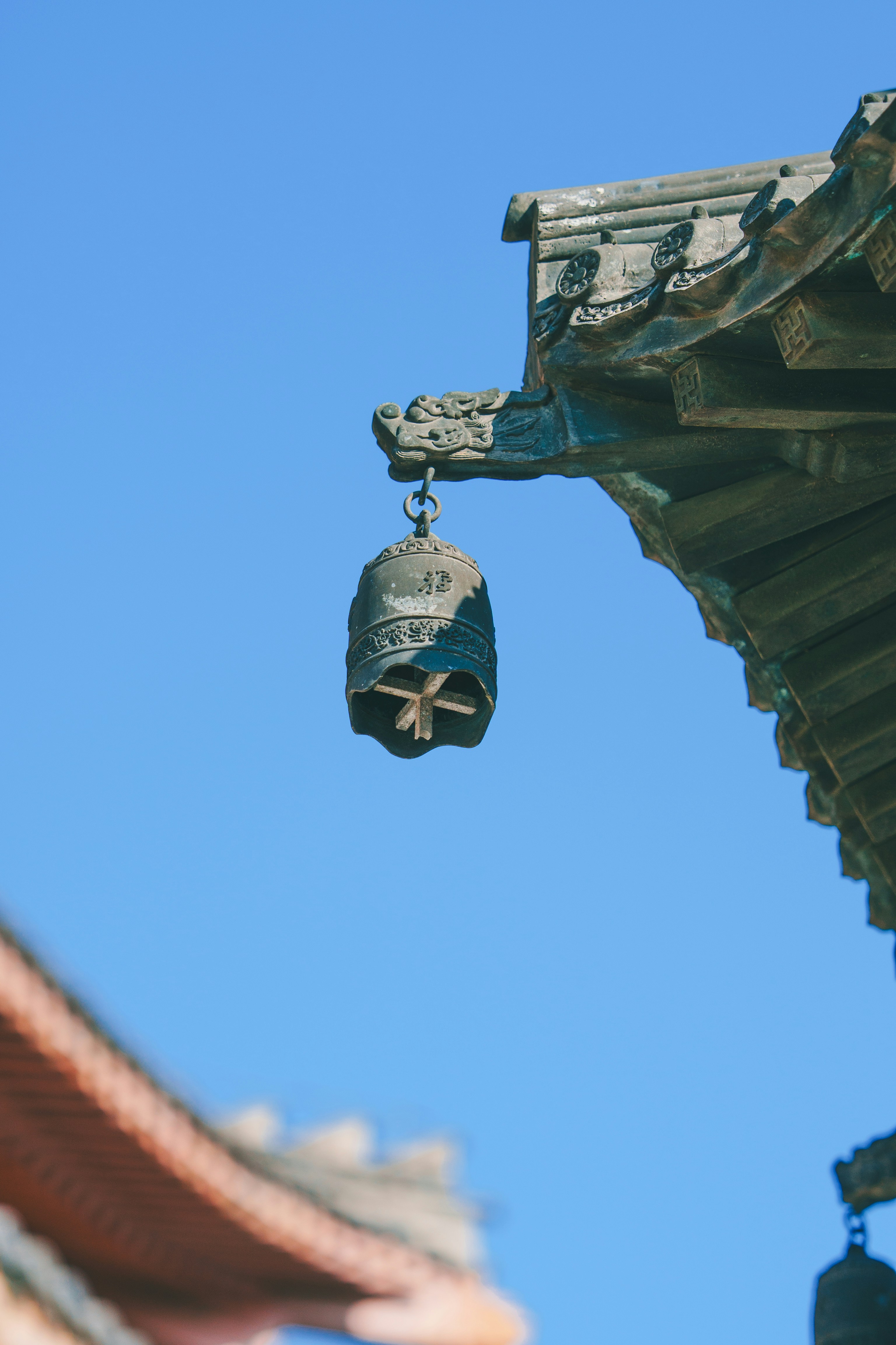 Hanging Lantern Ornament Against clear Blue Sky Heron Roof Detail
