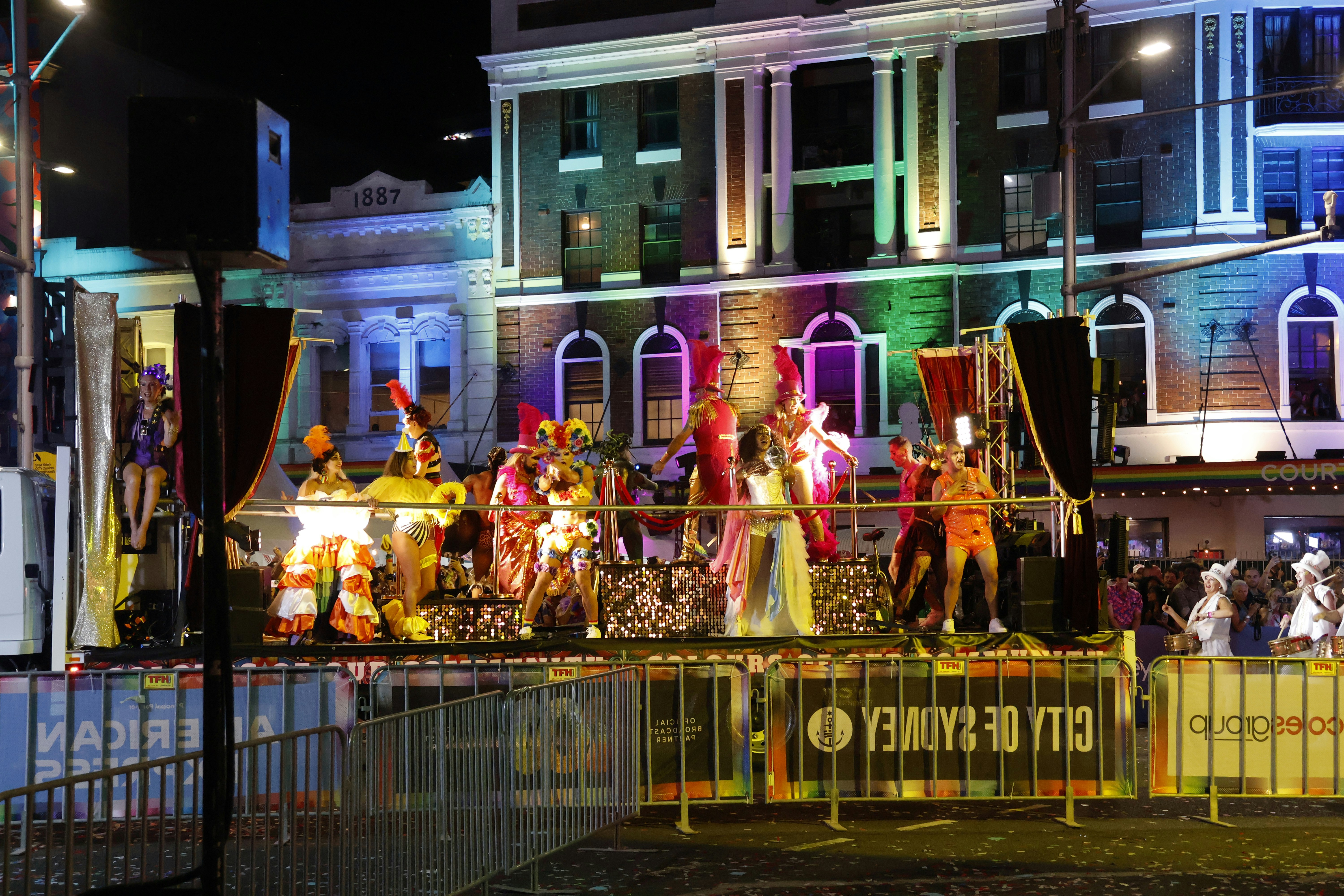 Nighttime Street Stage: Dancers in Colorful Lights on a Historic Facade
