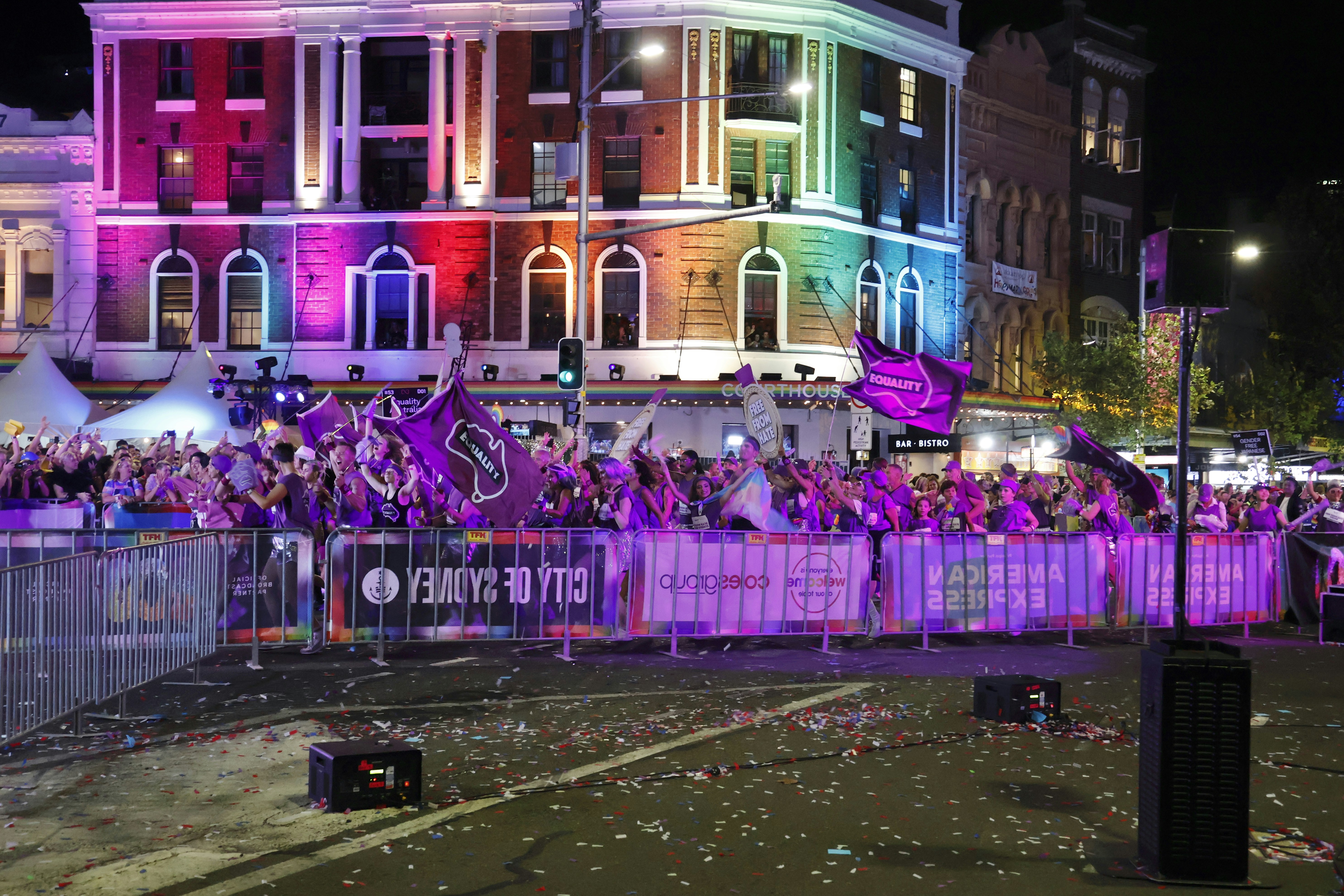 Rainbow-lit Street Party: A Crowd in Front of a Colorful Historic Building