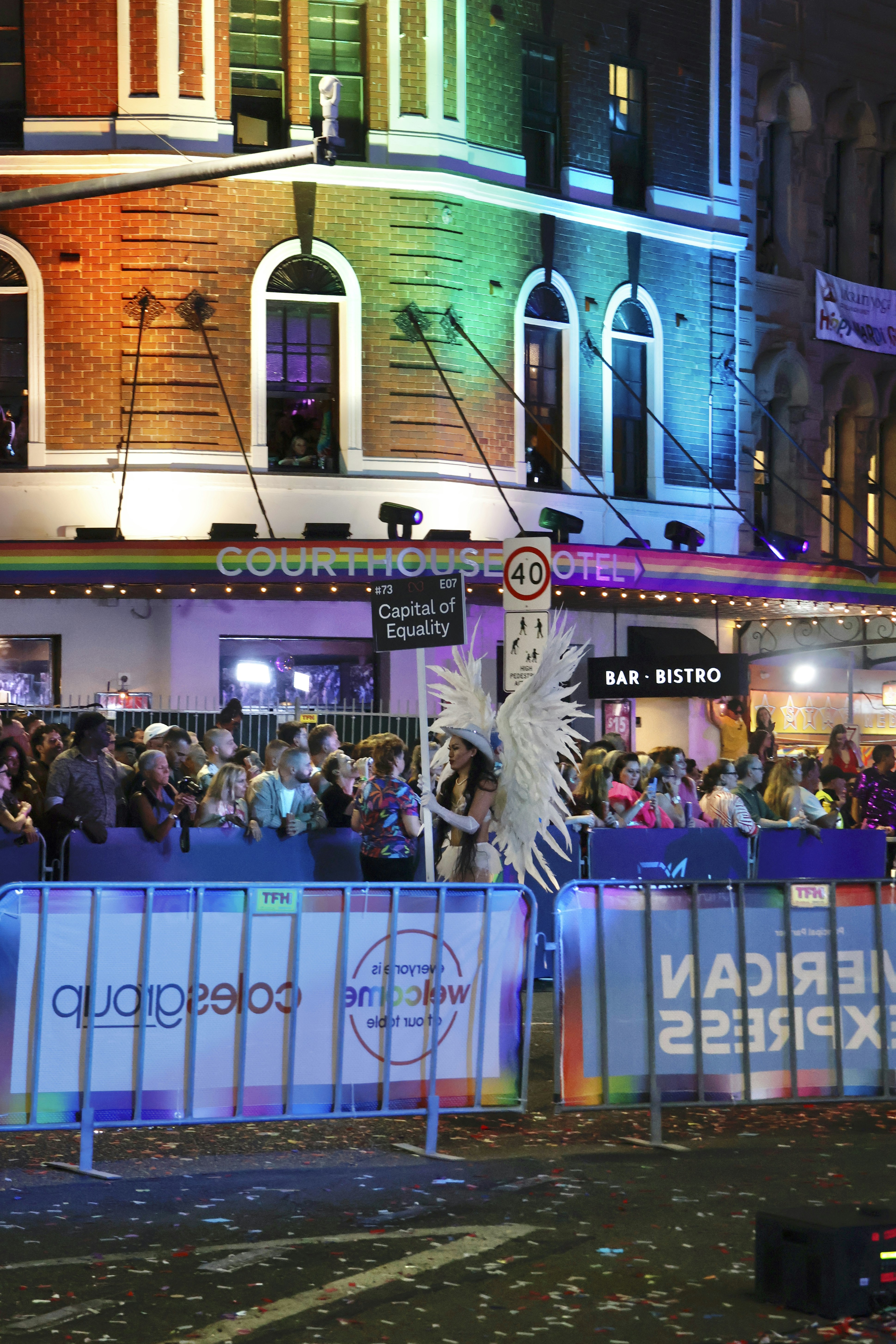 Winged Performer Under Rainbow Facade at Night Parade