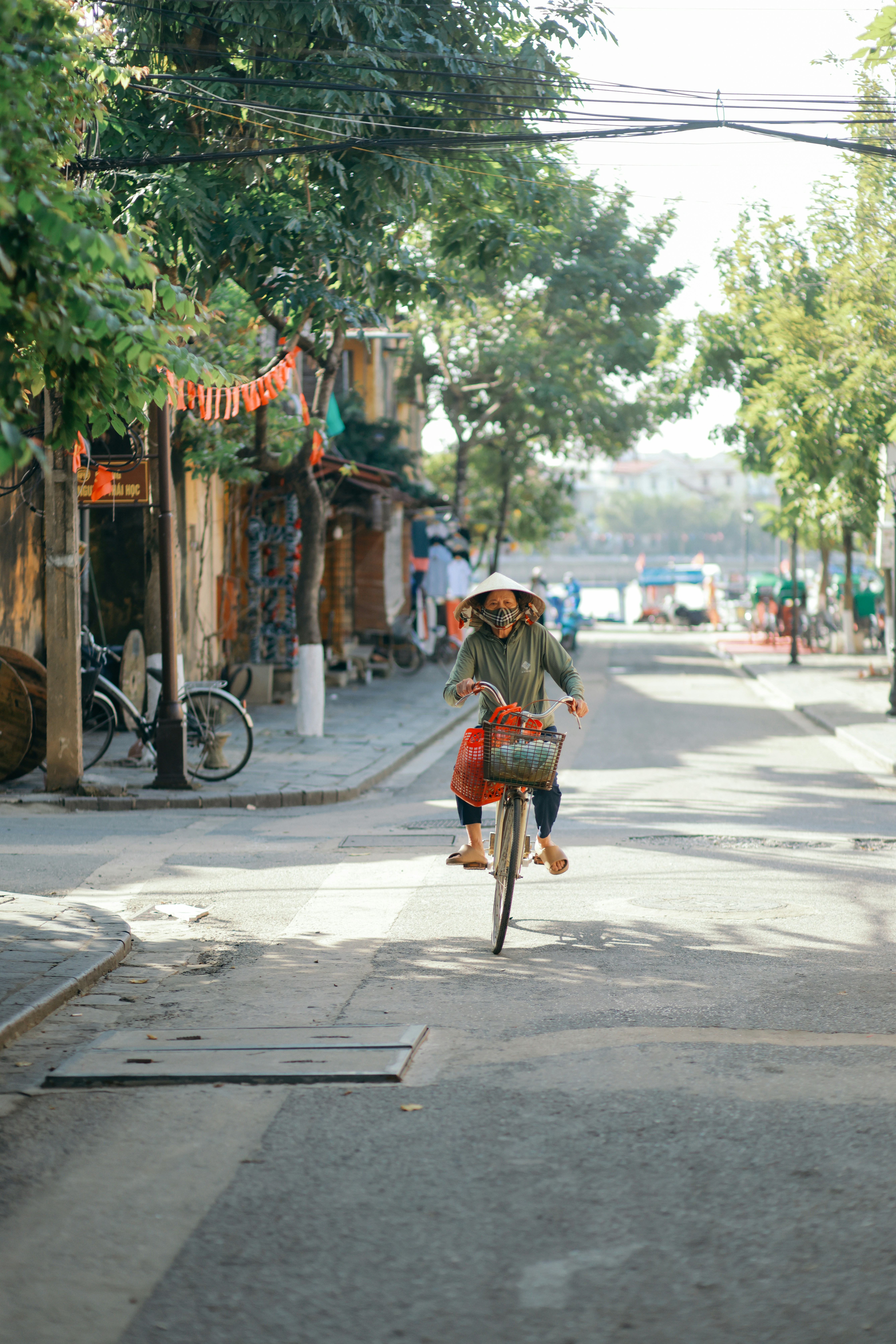 Mujer con sombrero cónico monta en bicicleta por la calle. foto ...