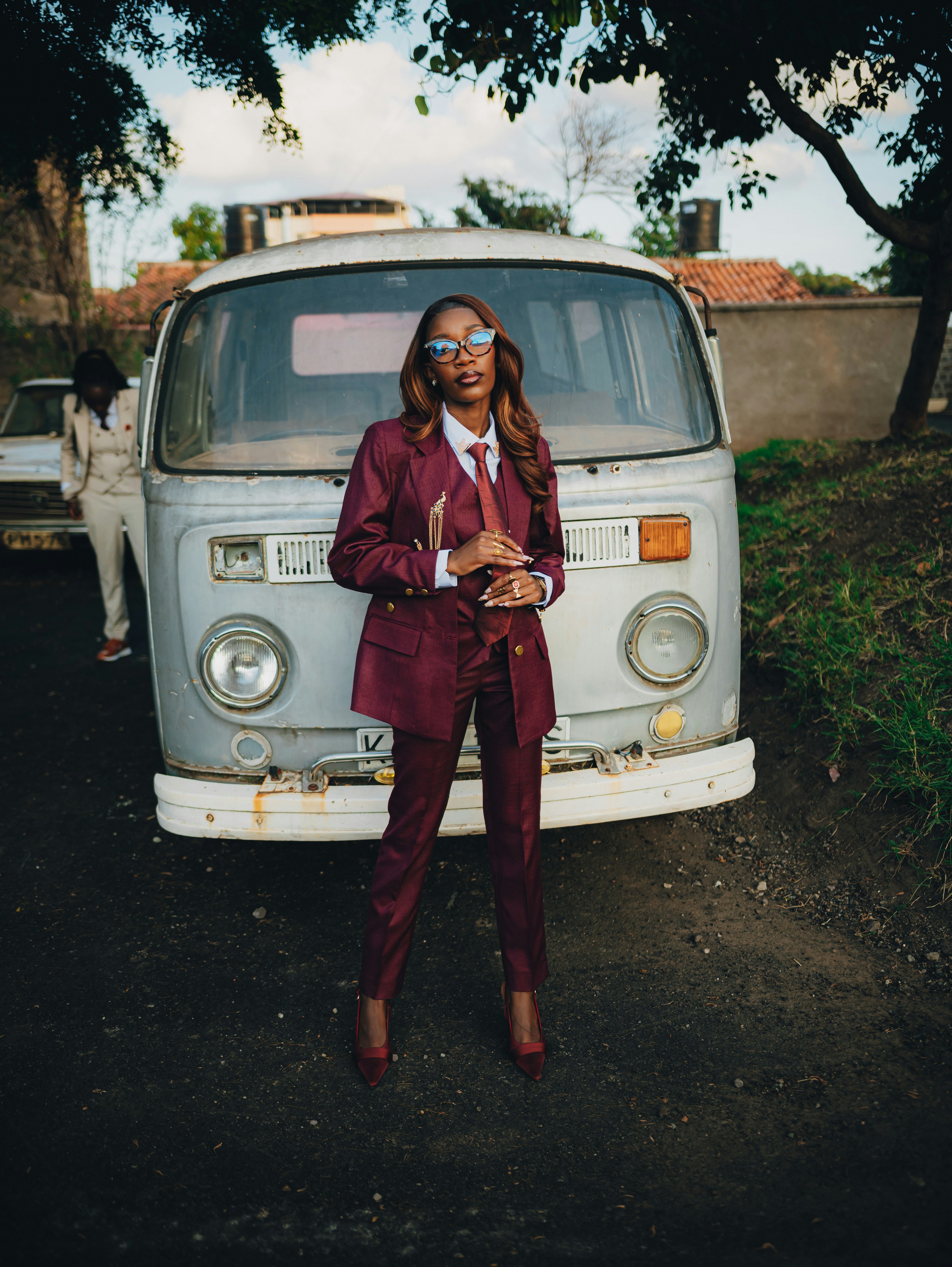 Sophisticated Stance: A Burgundy-Suited Moment by the Vintage van