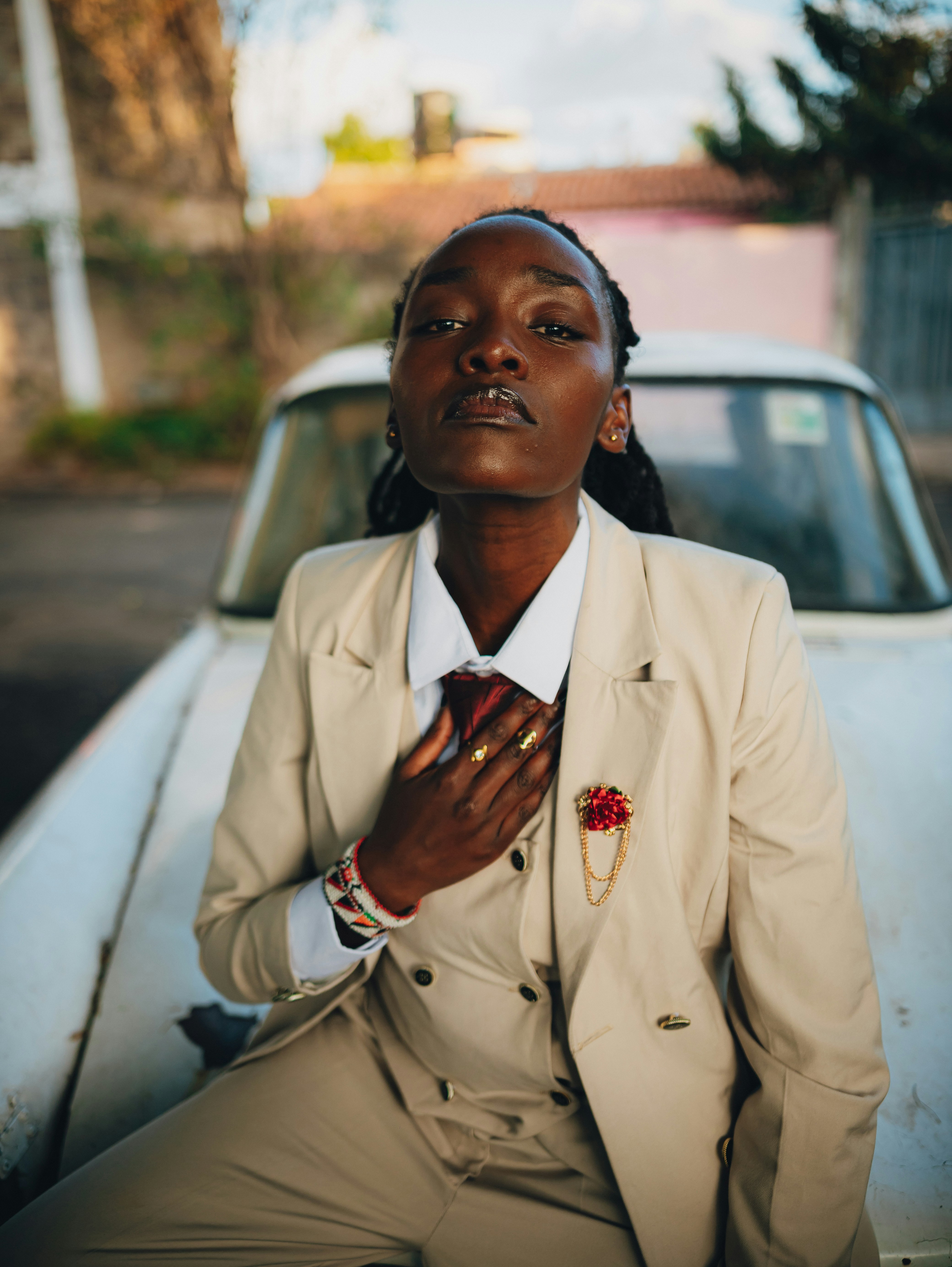 Bold Portrait in Beige: Authority and Style Against a Striped Car Backdrop