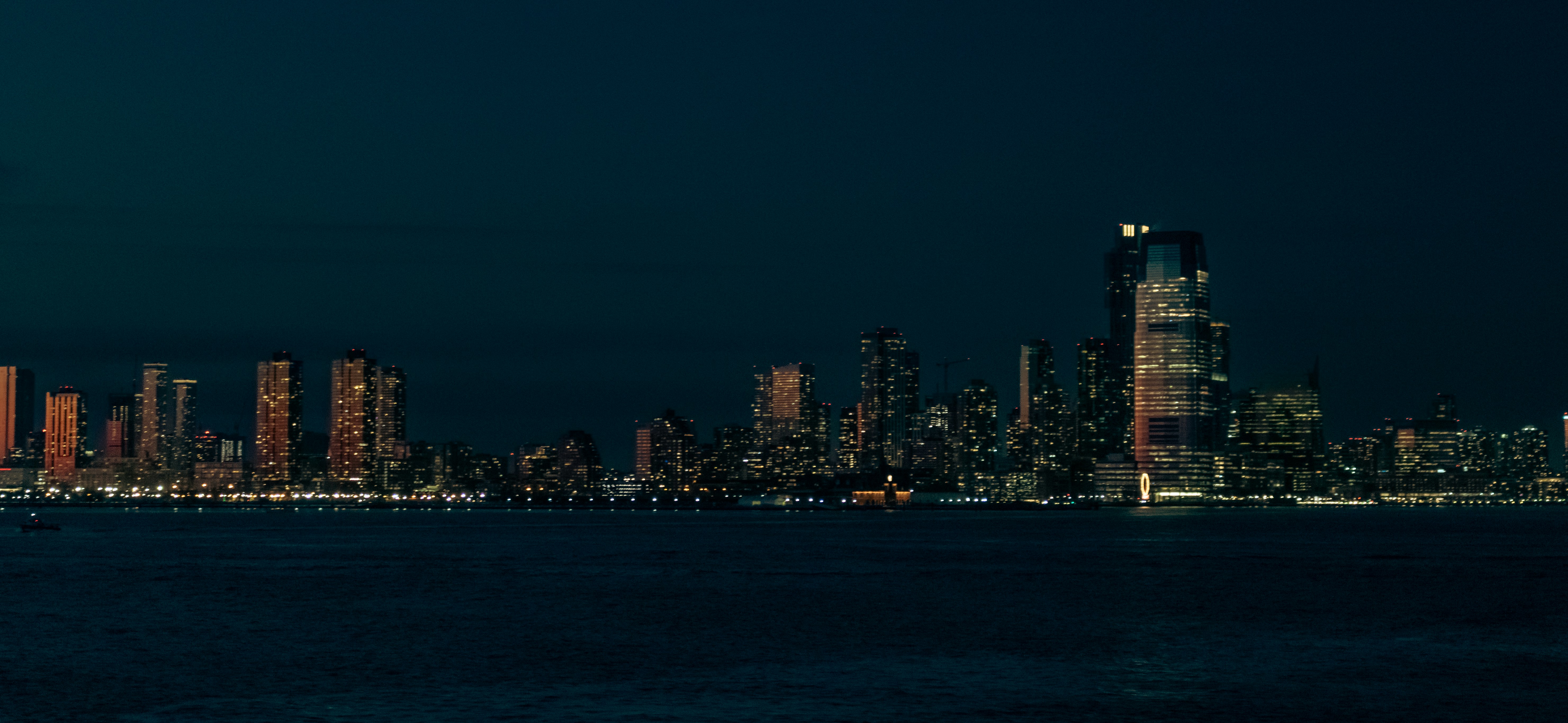 City skyline illuminated at night over water photo – Free Building ...