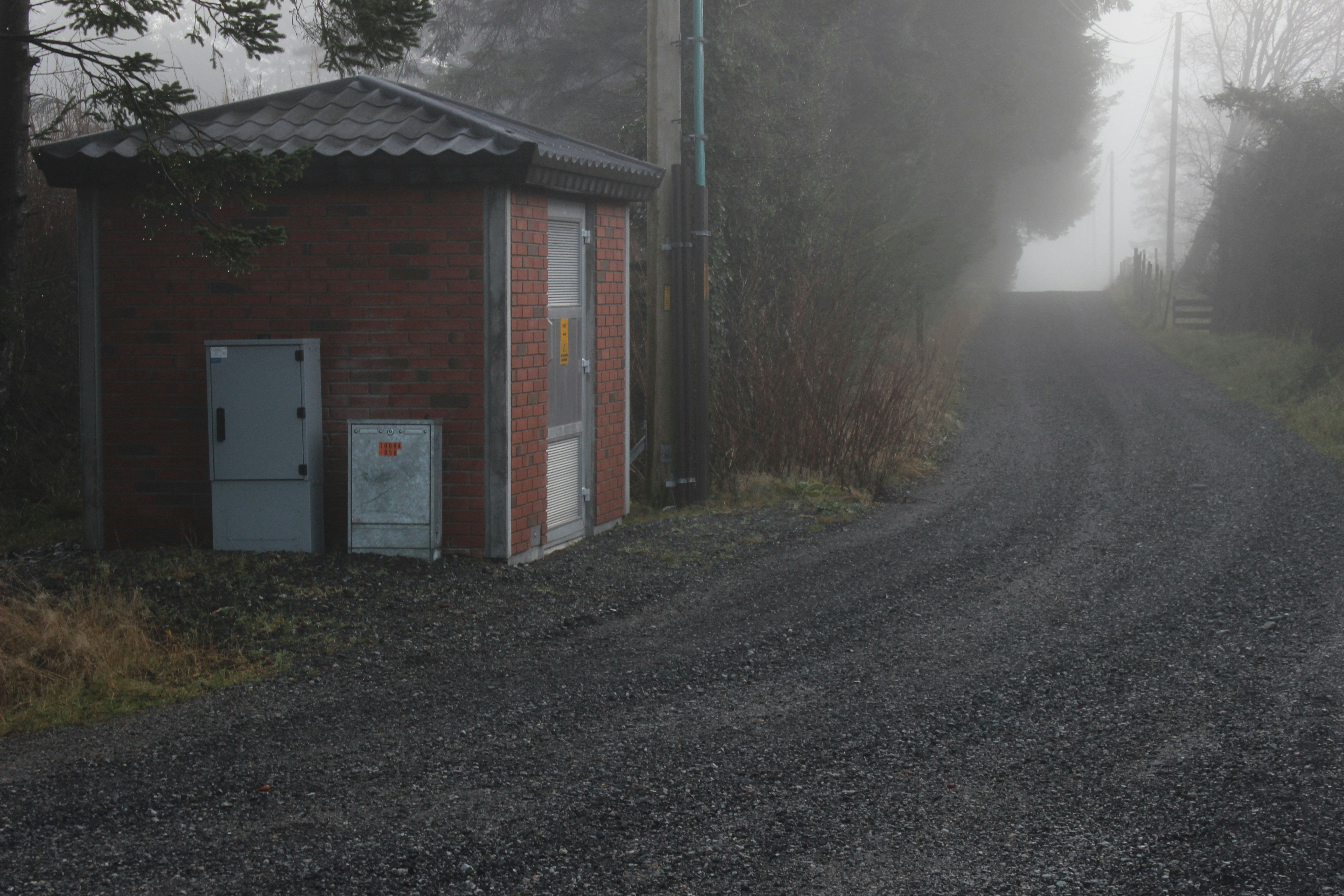 Foggy Gravel Lane Beside a Small Utility Shed