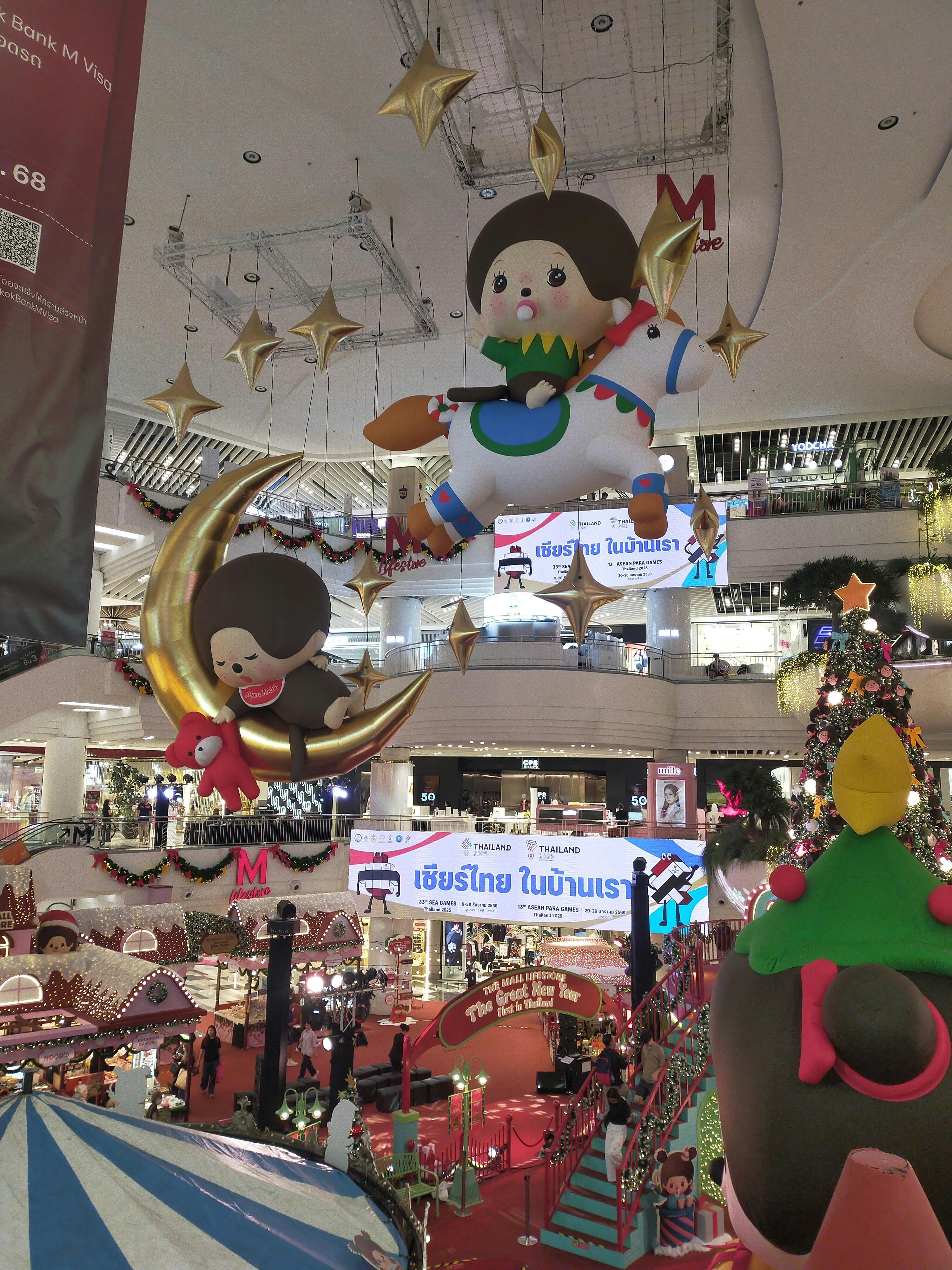 Large inflatable decorations of children riding animals in a mall.