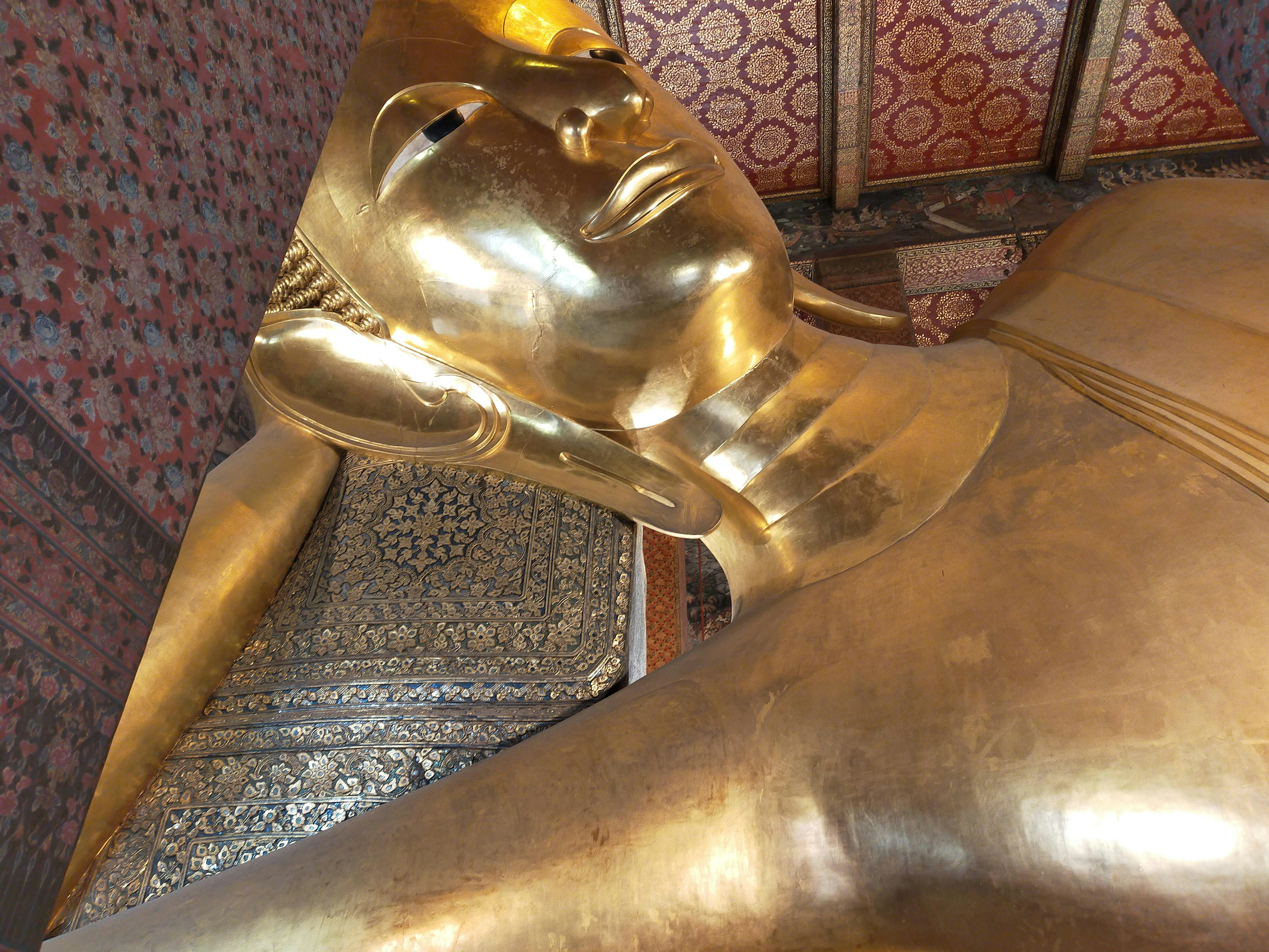 Golden reclining buddha statue indoors