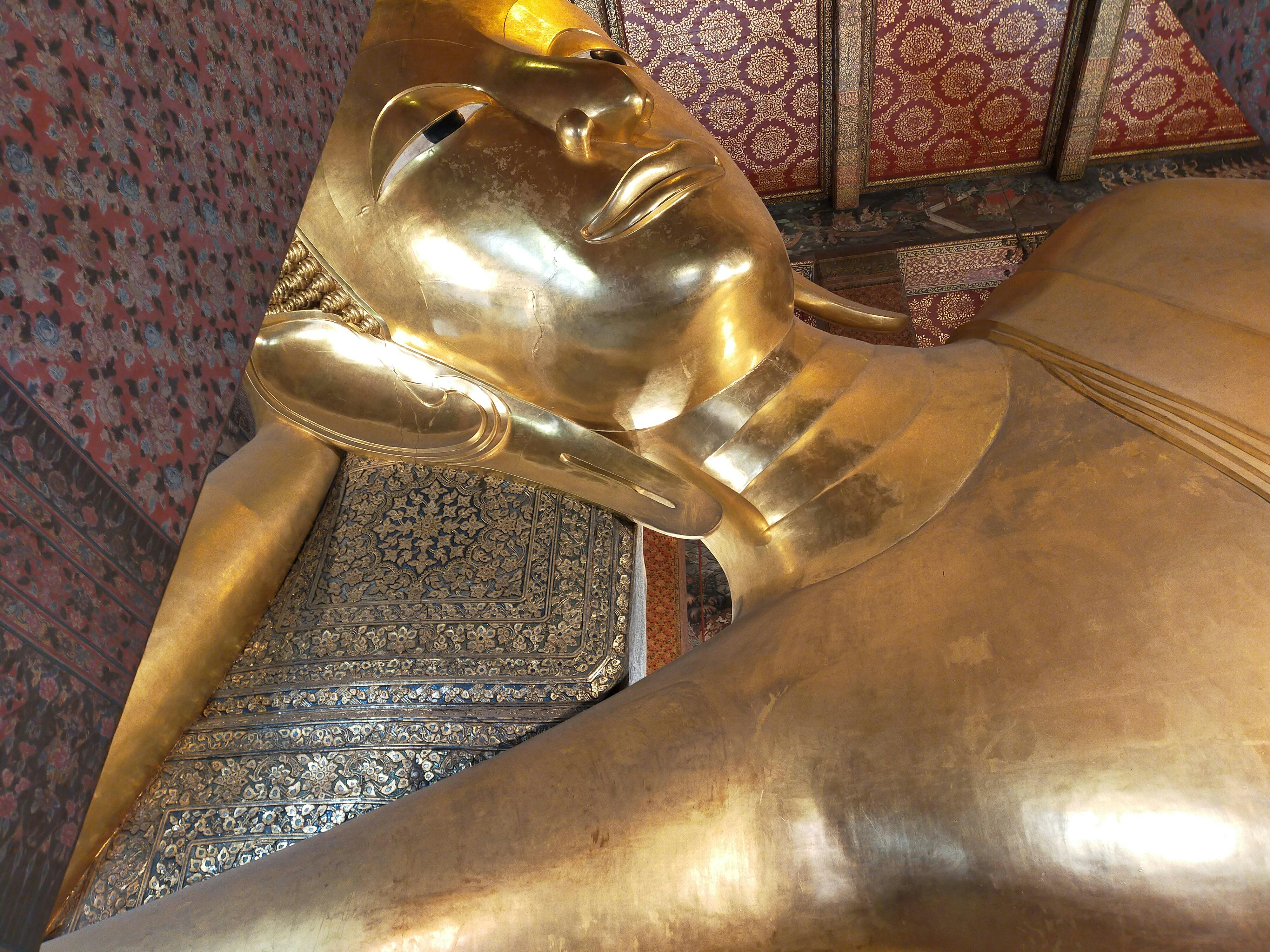 Golden reclining buddha statue indoors