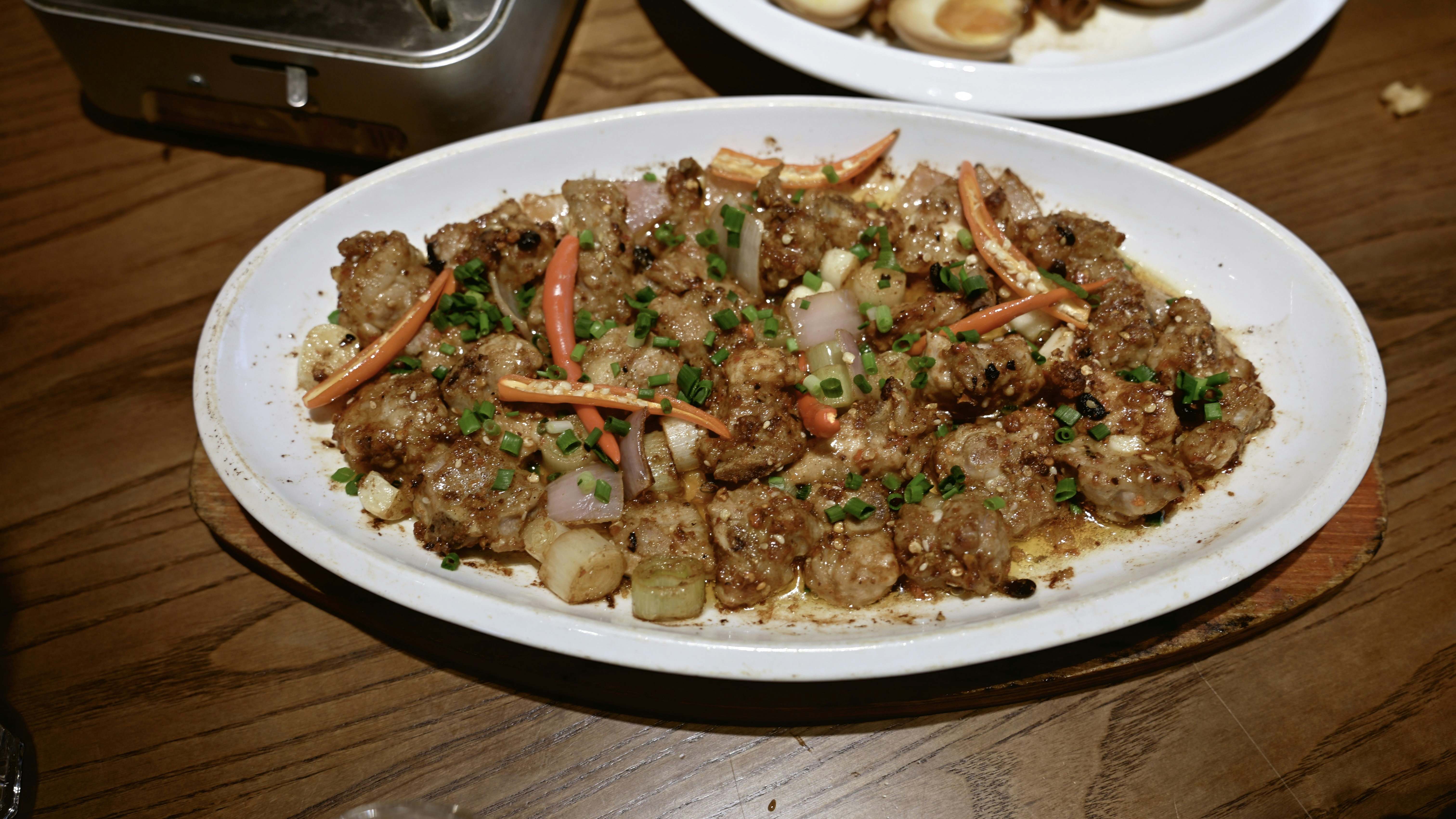 Crisped Cubes of Beef with Glazed Sauce and Sesame on a White Plate
