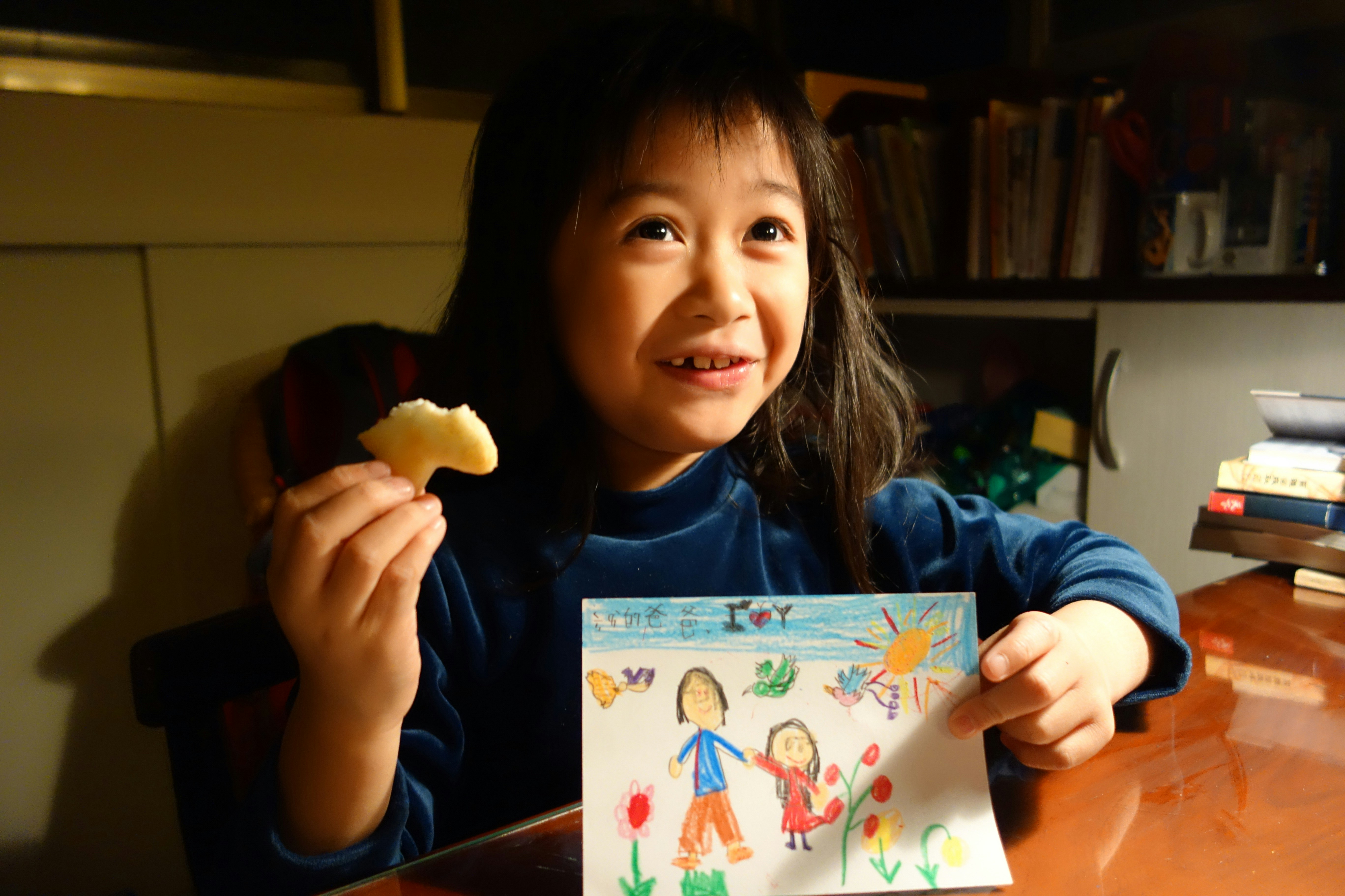 Little Artist, Big Smile: A Child Displaying Her Drawn Joy