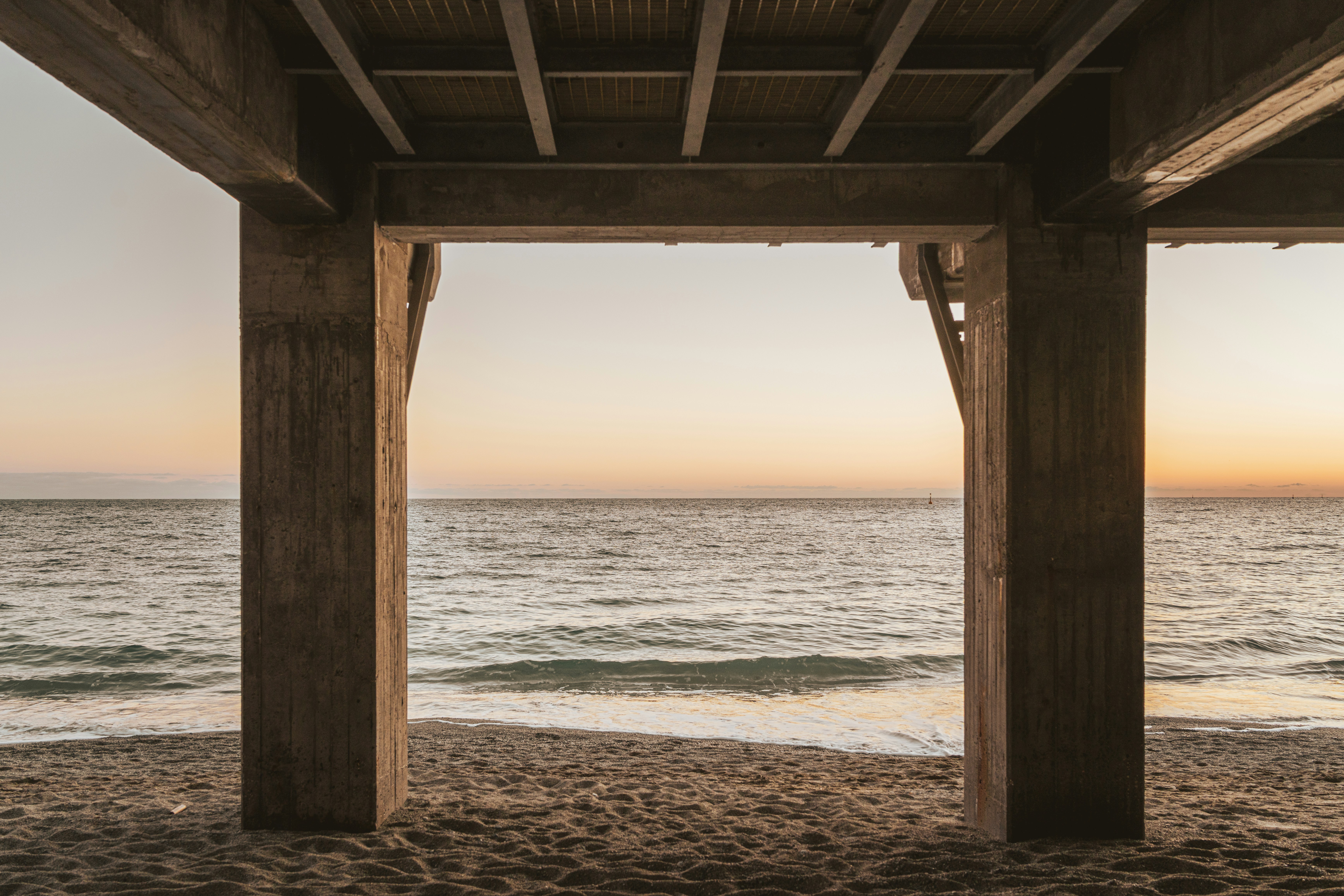 Sunset Under the Pier: Quiet Horizon Framed by Concrete Beams