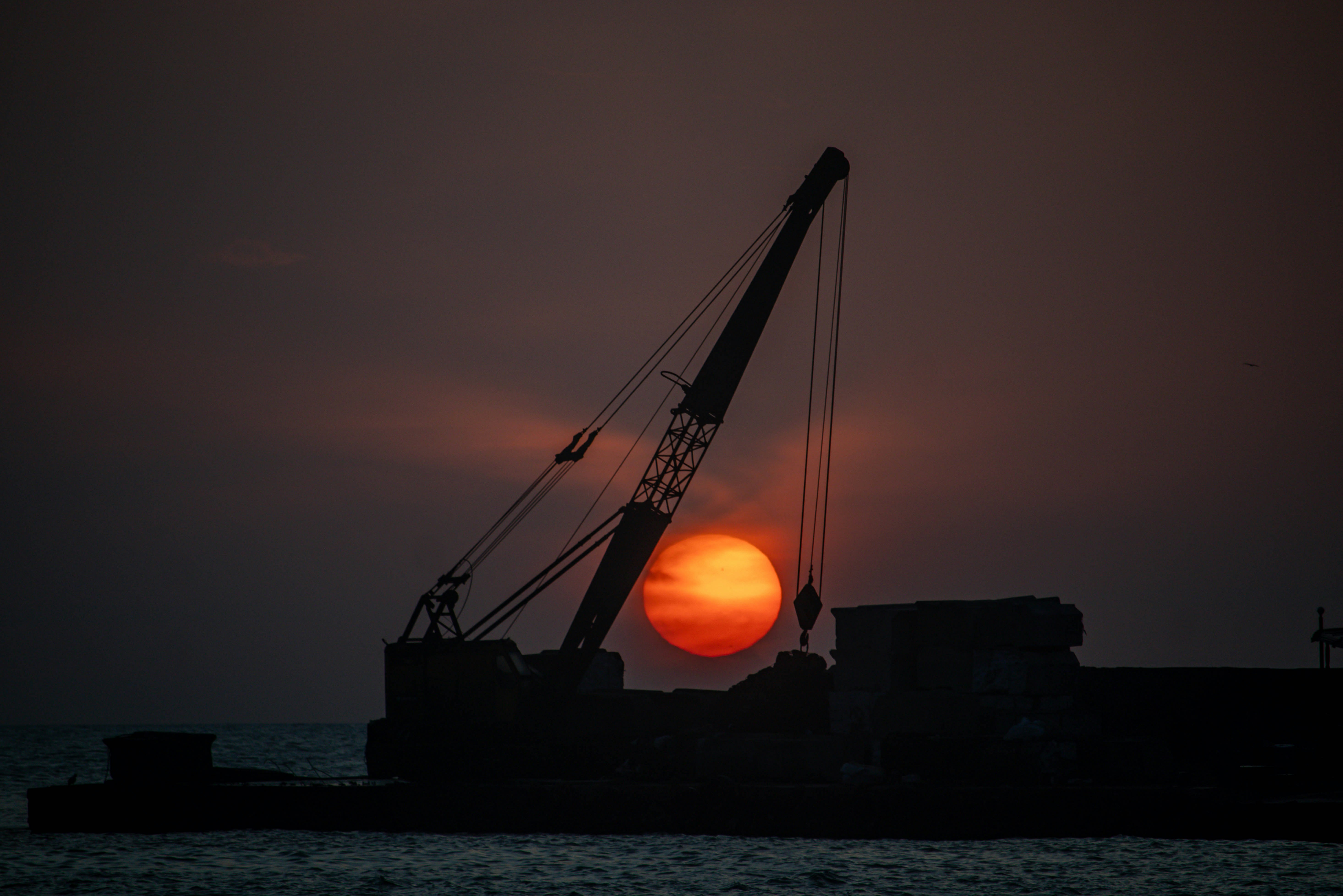 Crucible at Dusk: A Crane Cradling the Sun