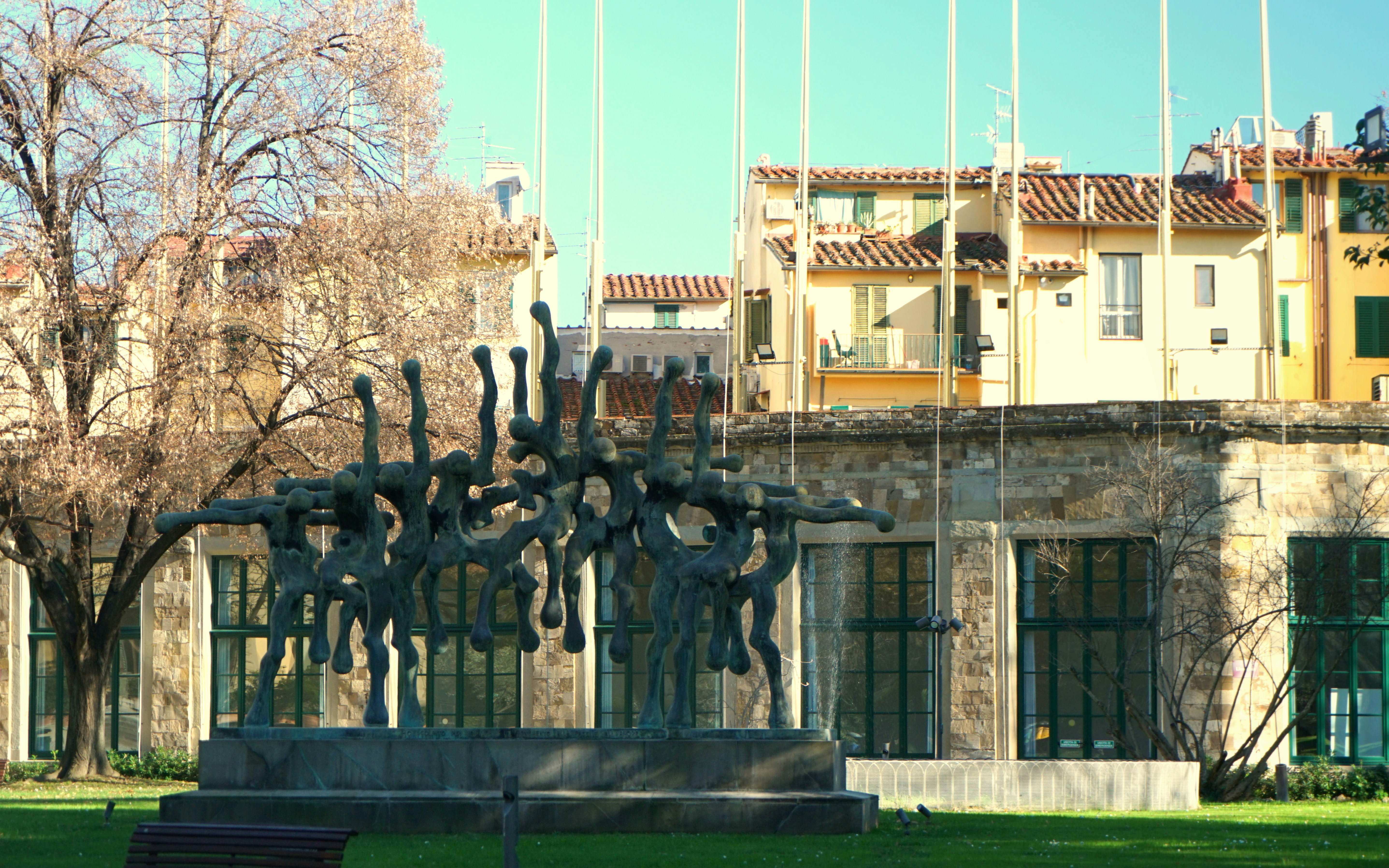 Sculpted figures in a sunlit plaza