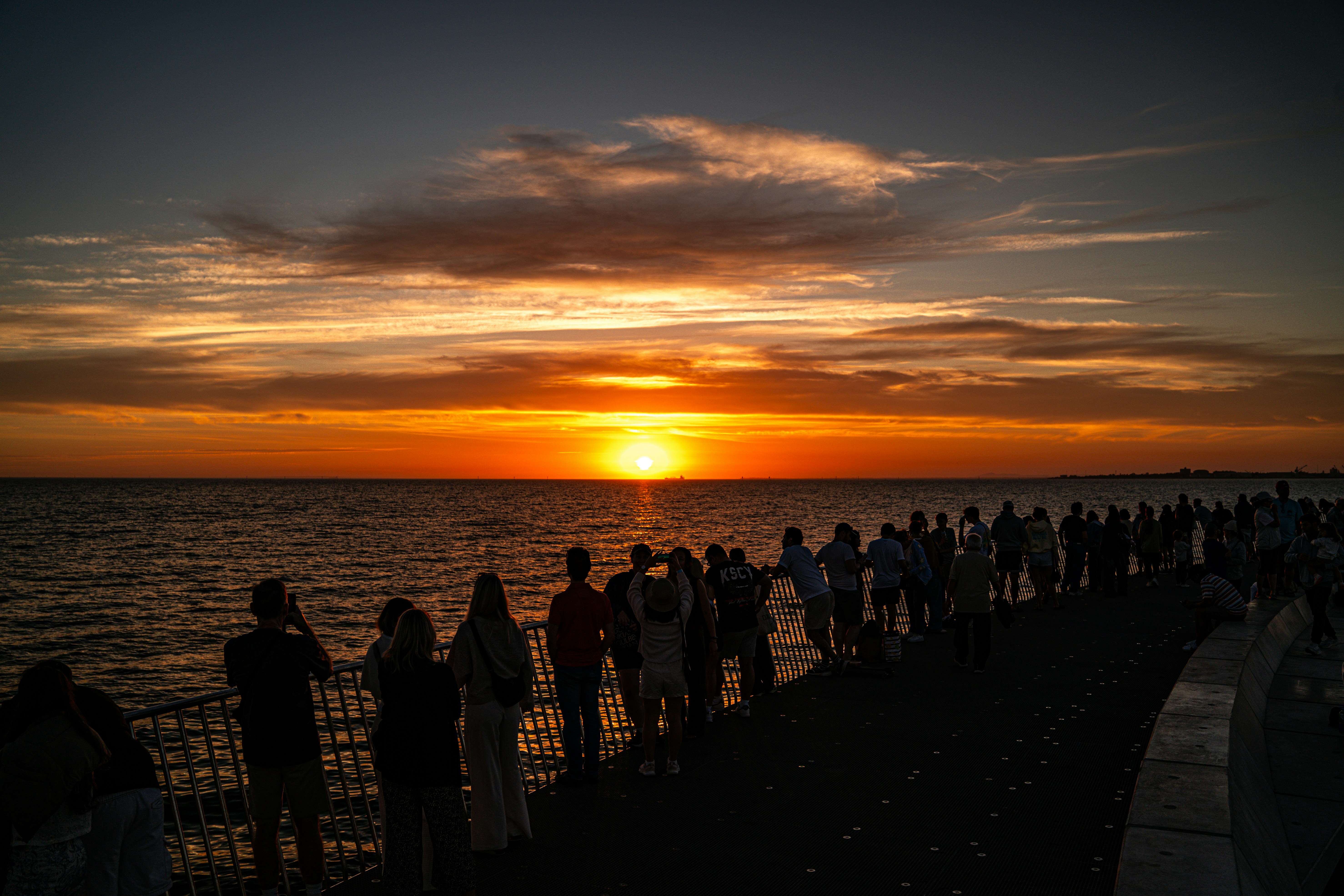 Sunset Walkway: A Crowd Gathers at Dusk on the Pier