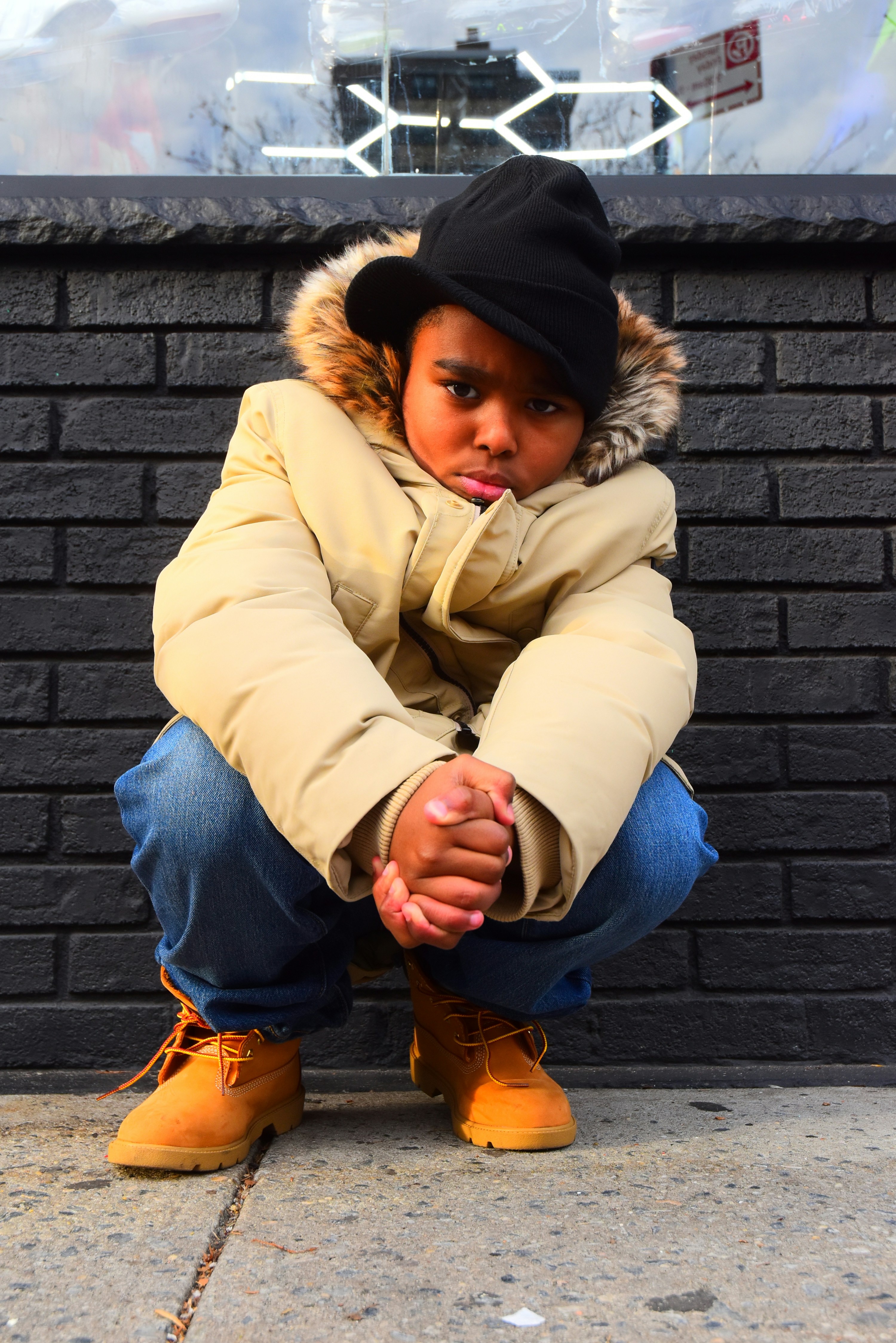 Crouched Portrait: A Warm Moment Against the Brick