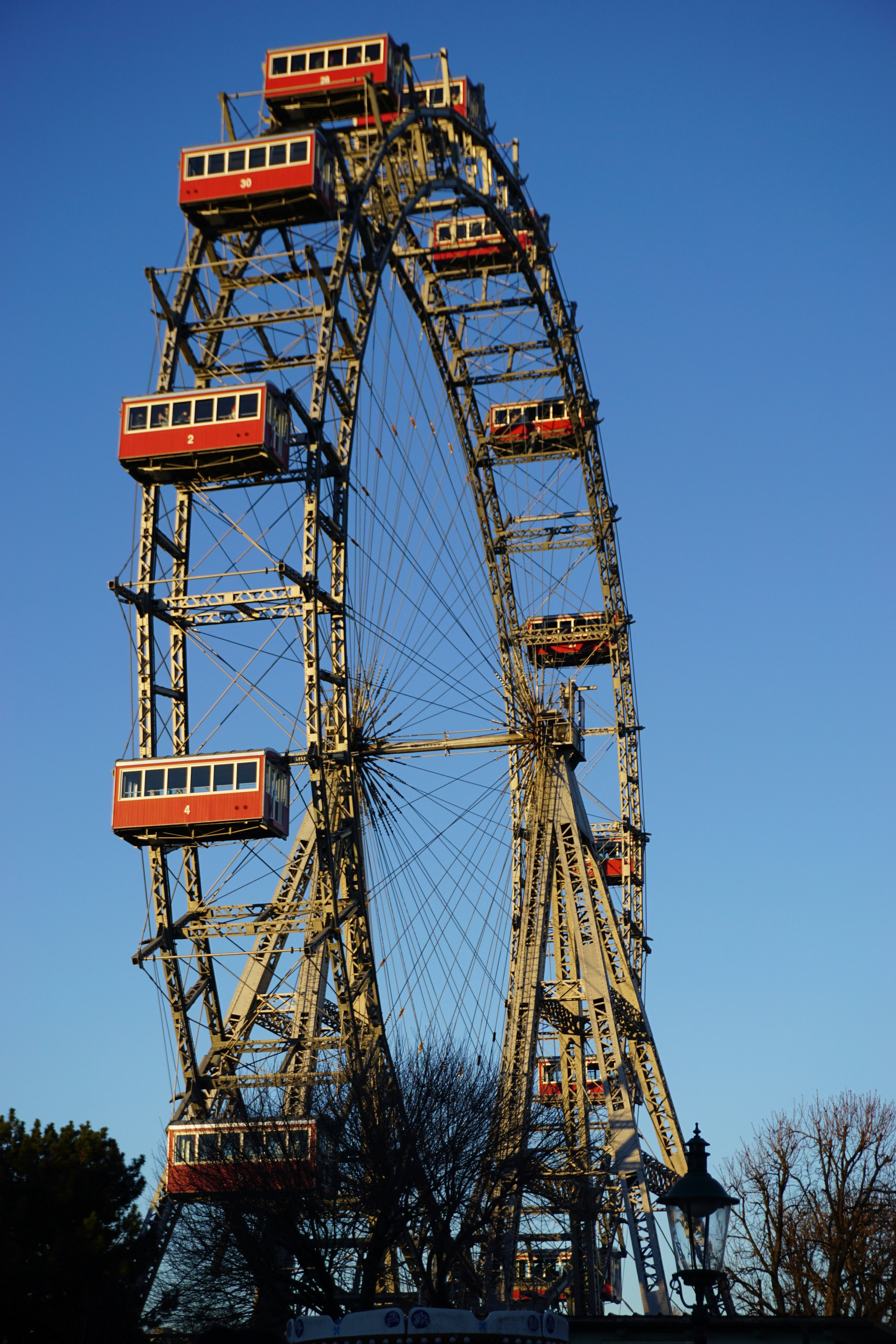Crimson Carriages ascend the steel arc of a towering ferris wheel