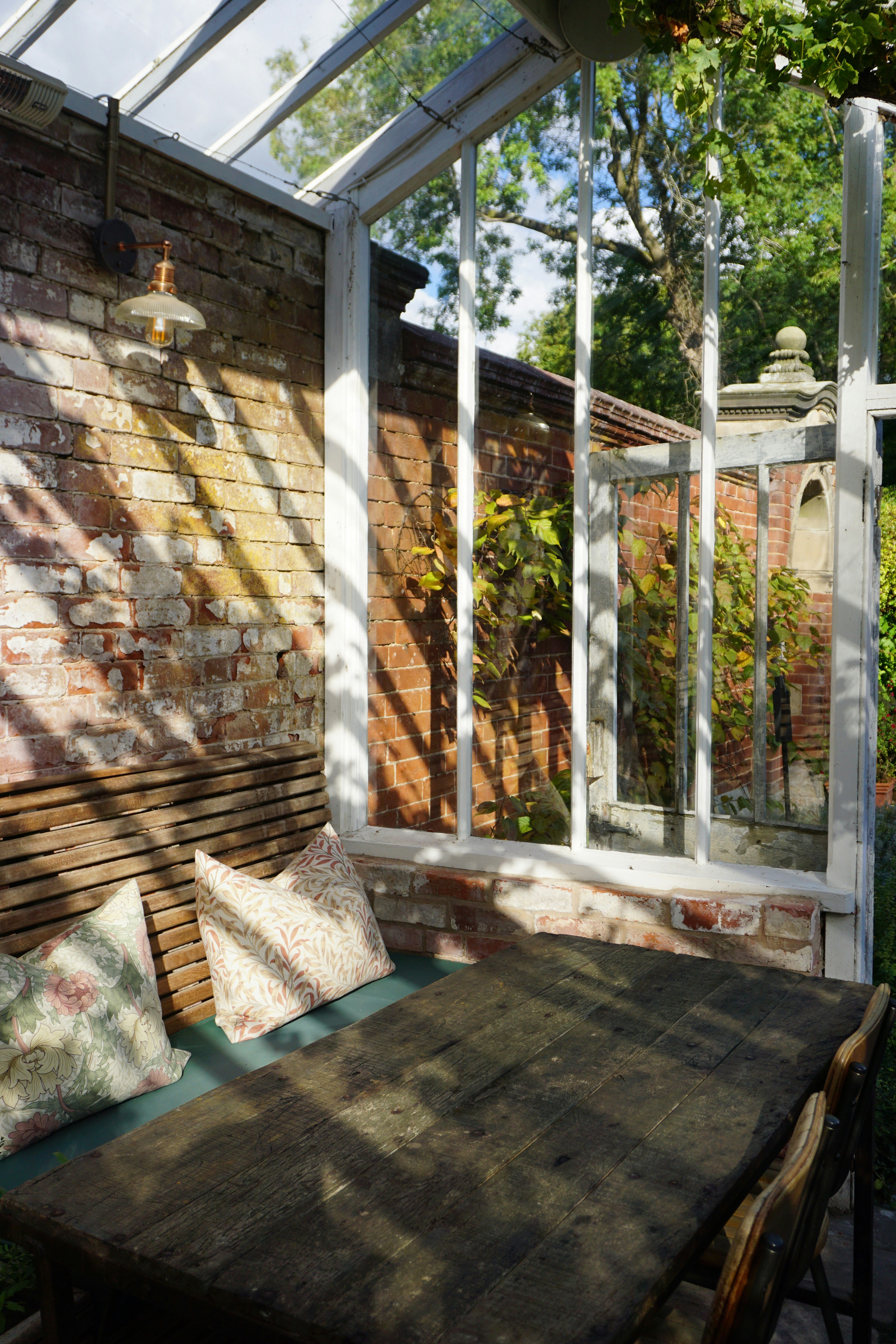 Sunlit Brick Conservatory Beside a Weathered Wood Table