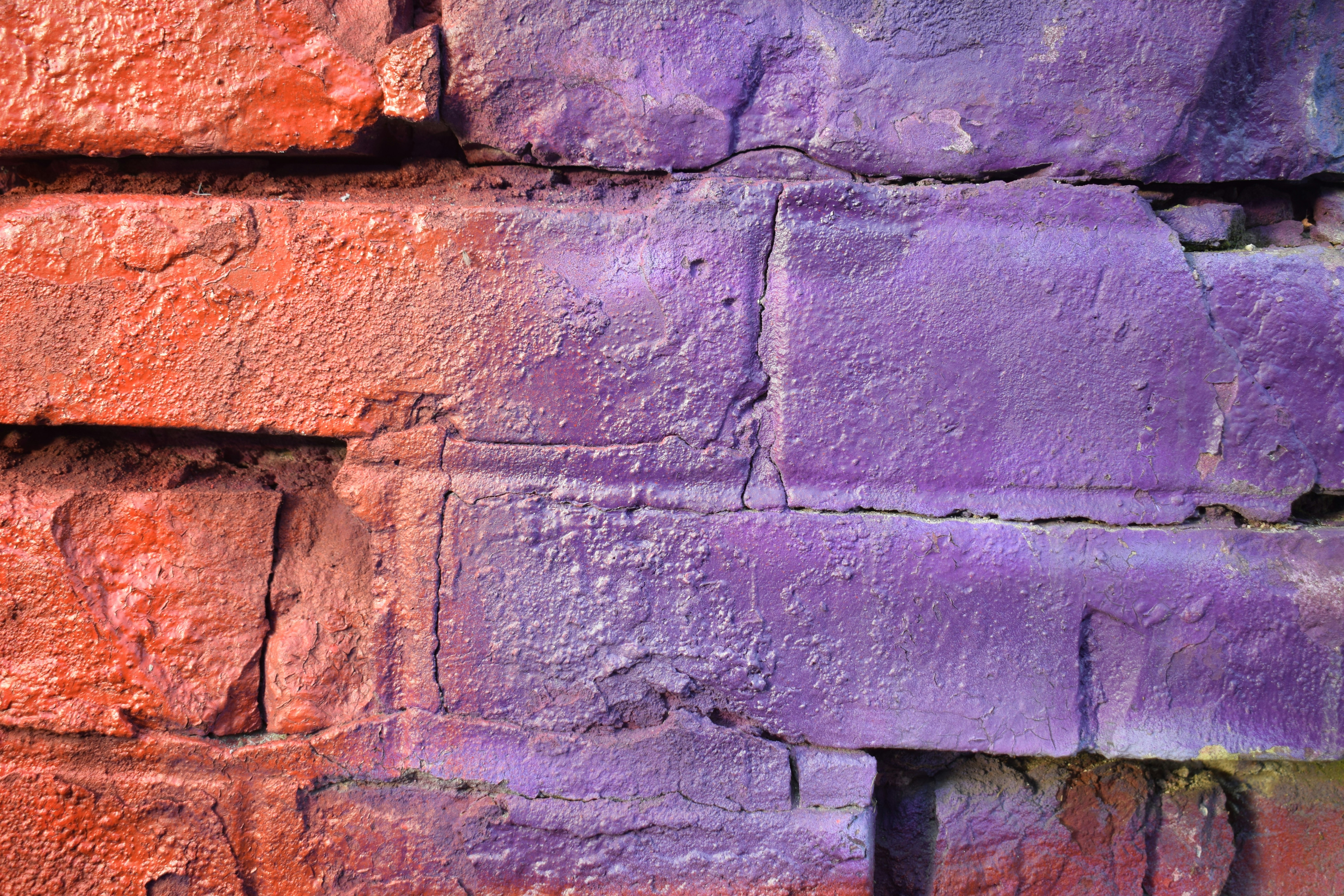 Color-blocked brick wall with orange and purple spray paint
