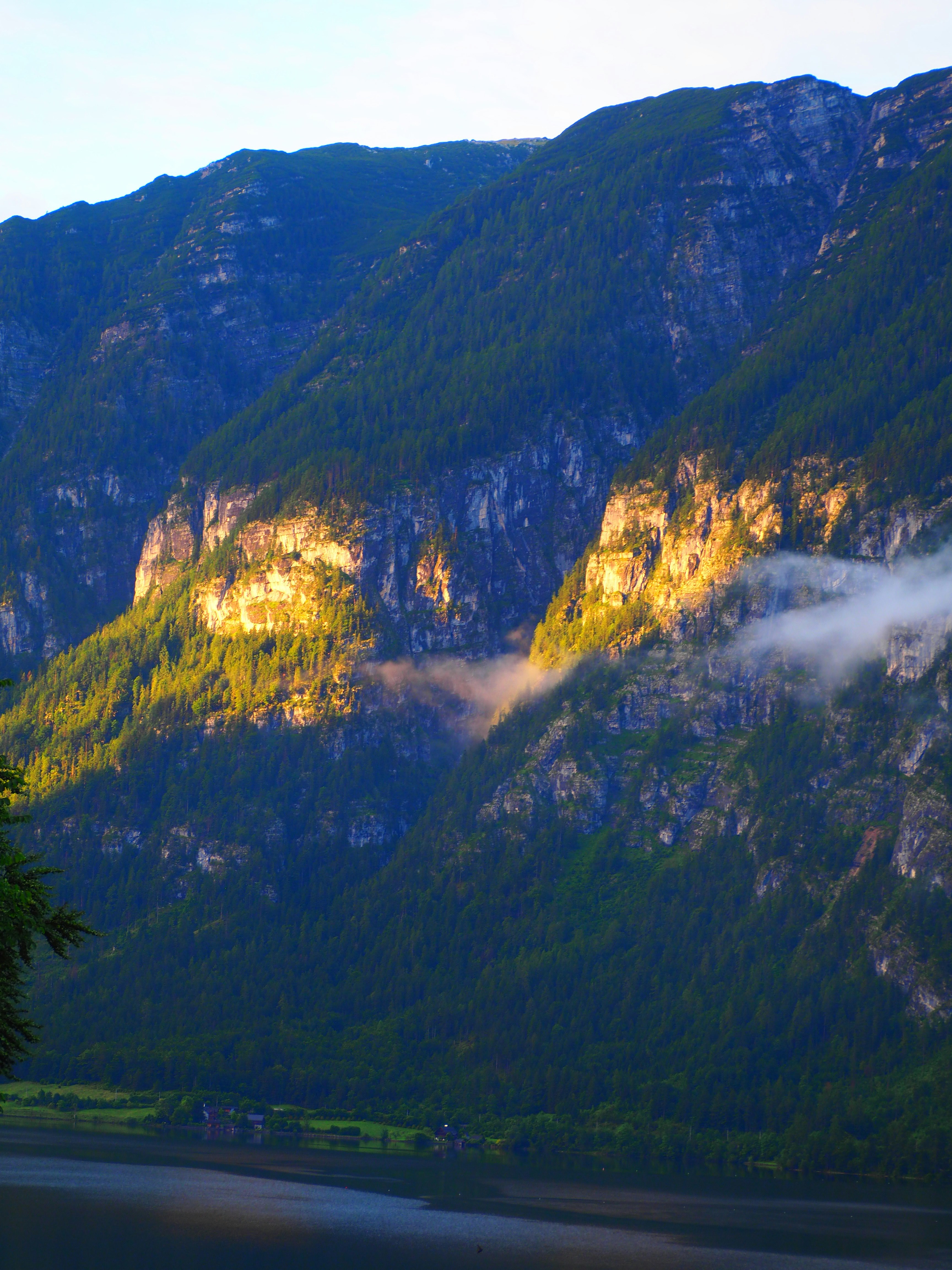 La luz del sol ilumina un paisaje boscoso de montaña brumoso. foto ...