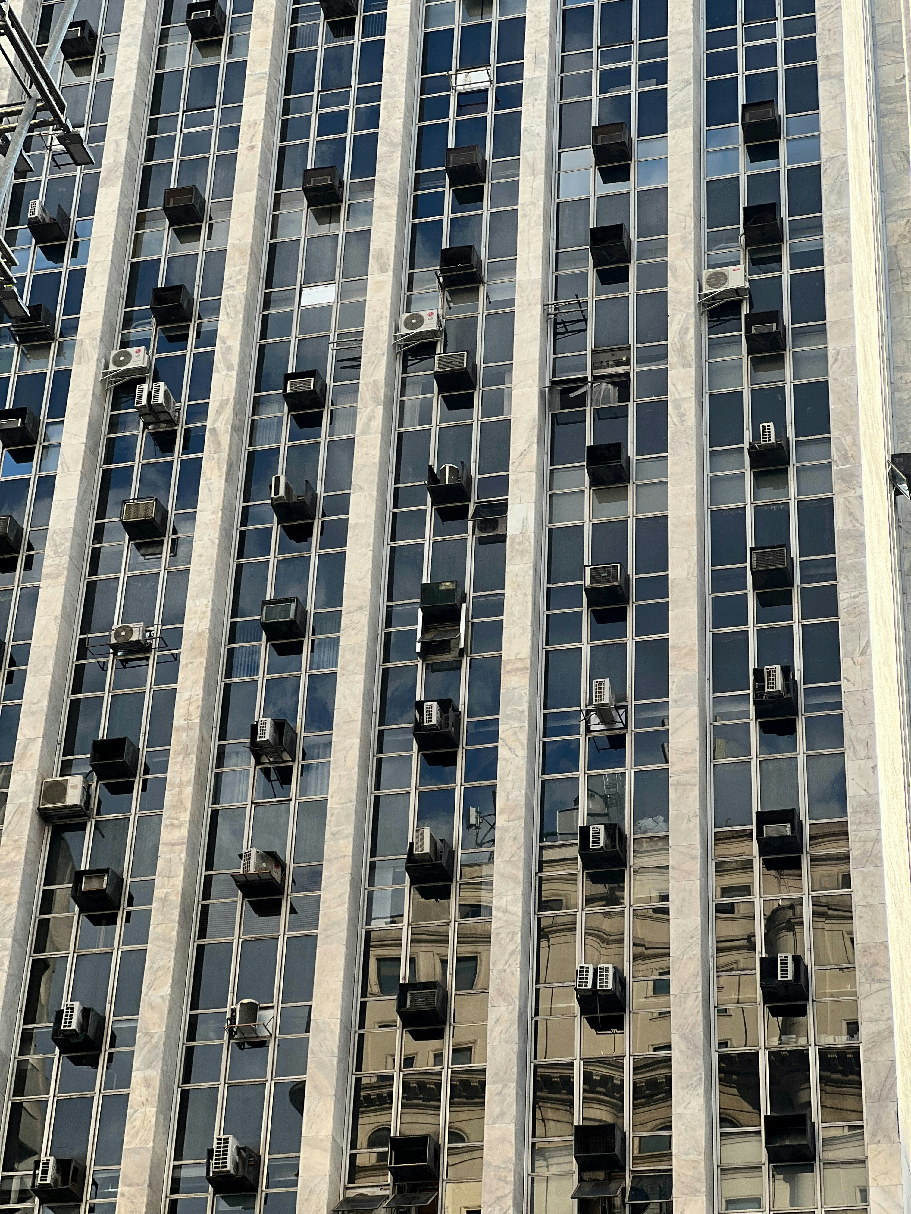 Vertical Gridwork: A City Facade Framed in Glass and Air Conditioners