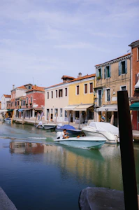 Colorful canalfront in motion: a sunlit boat ride beside pastel facades