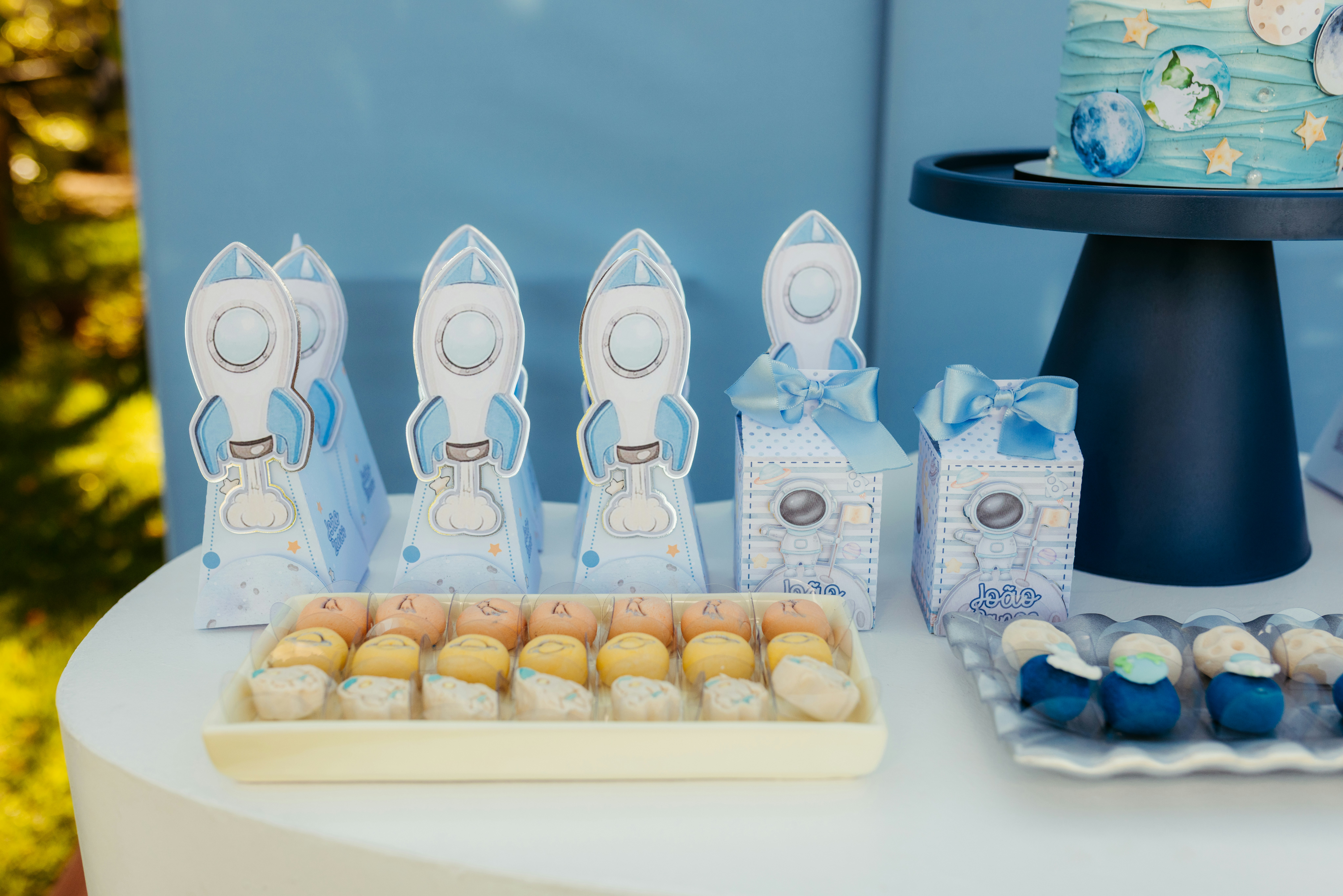 Pastel Rocket Party: Cake Toppers and Treats on a Soft Blue Table