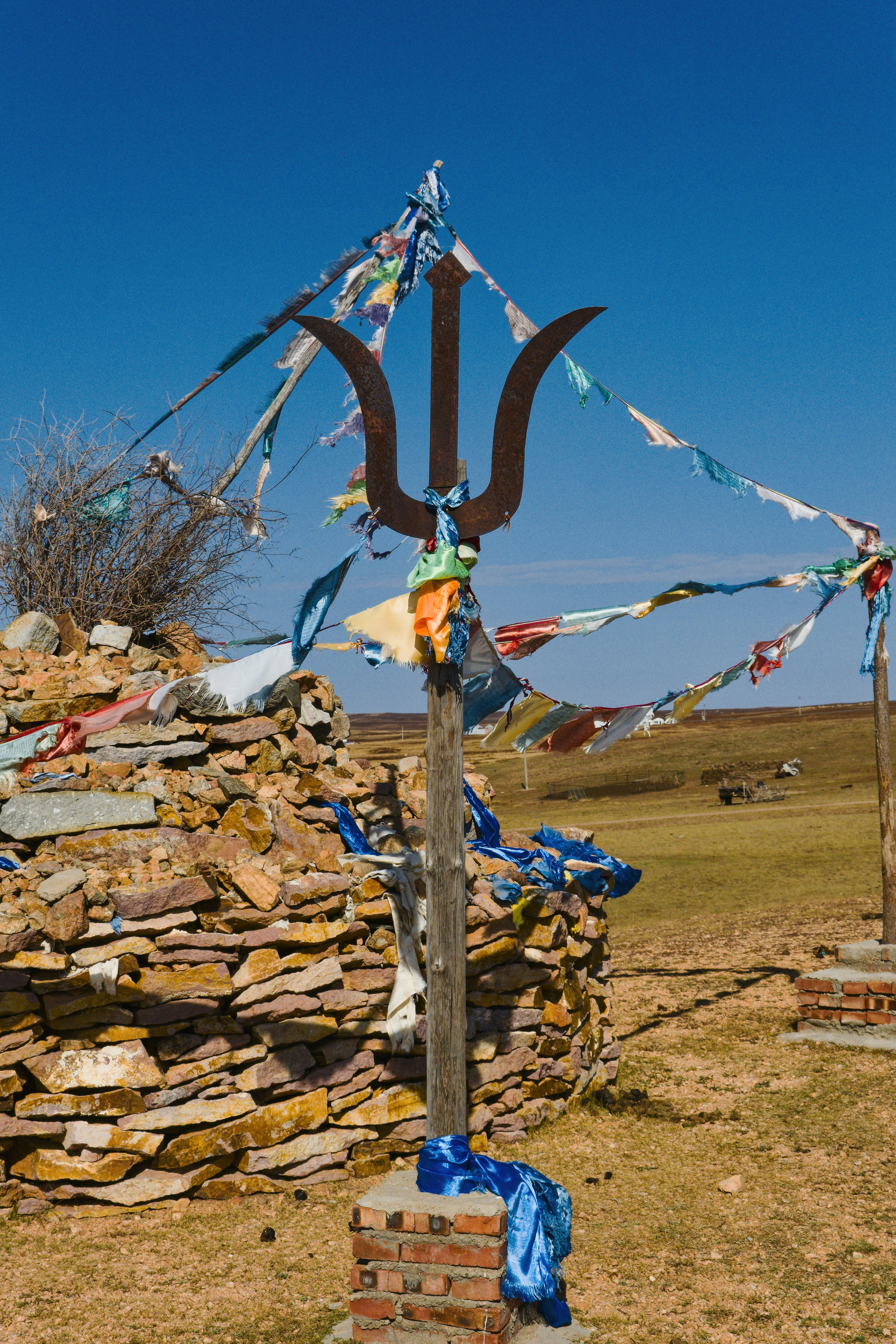 Prayer Flags and a Stone Stack Marking the Steppe Horizon