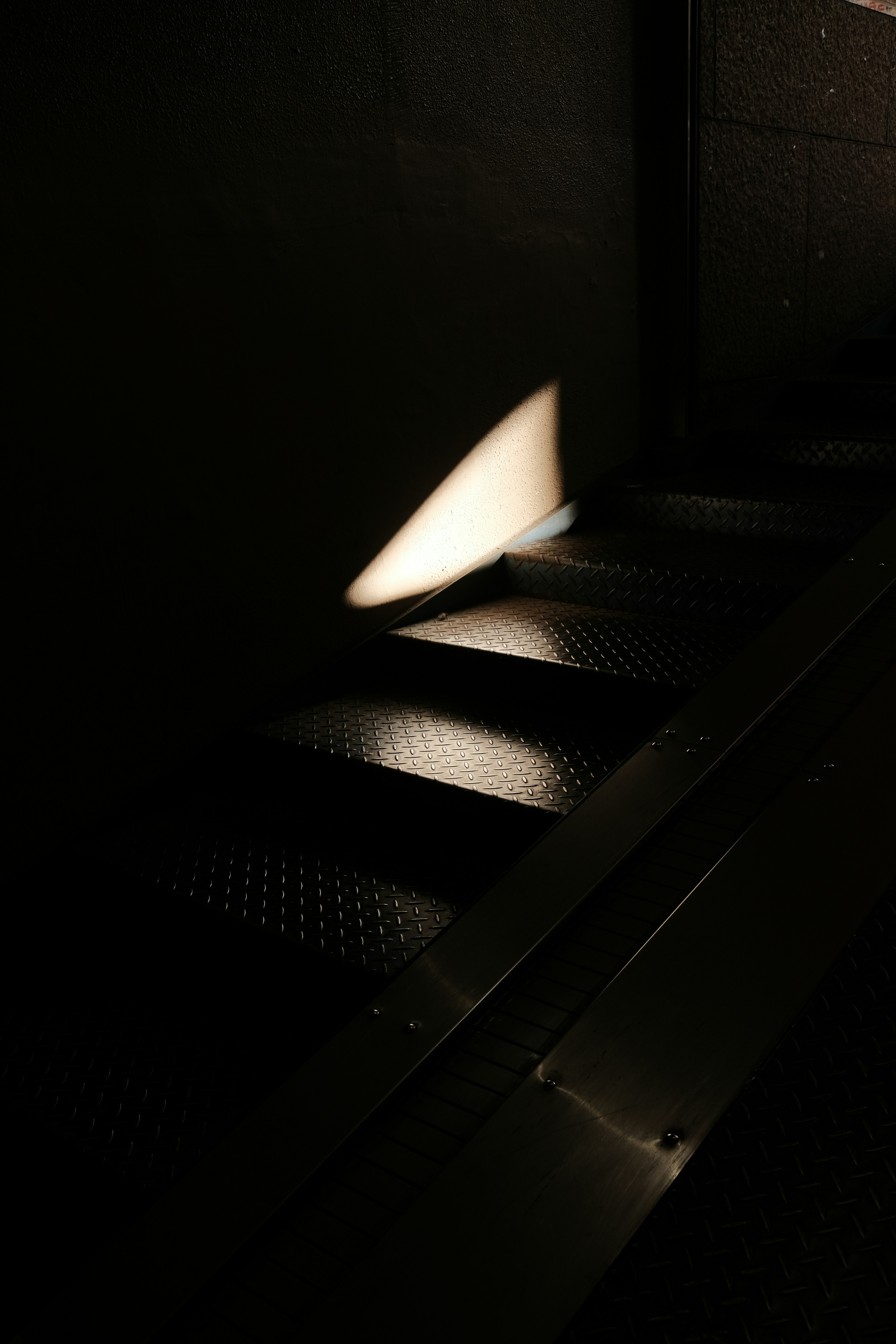 Shadowed Staircase: A Beam of Light on Industrial Steps